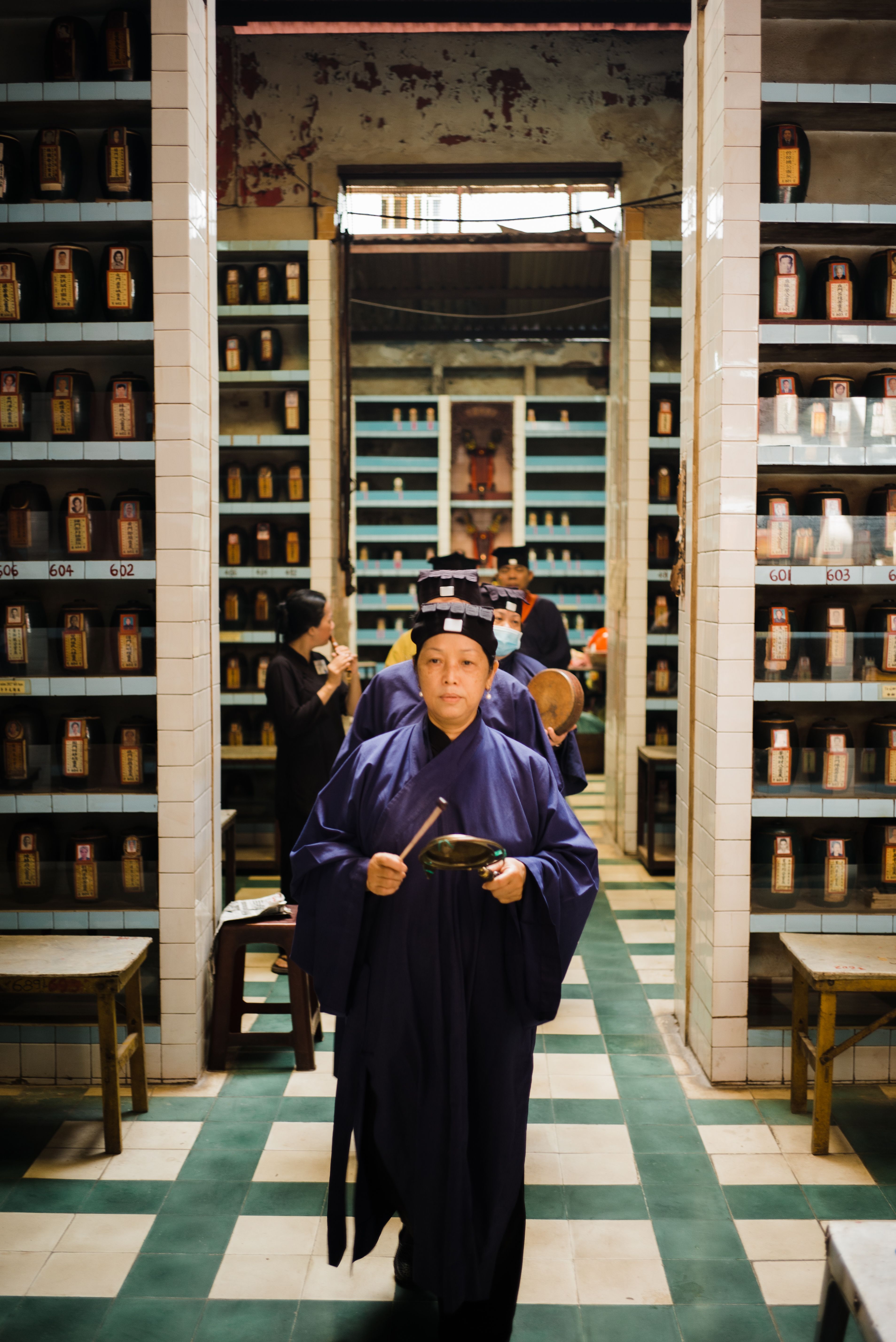 A Line of People in Traditional Gowns Standing in a Building with Tall ...