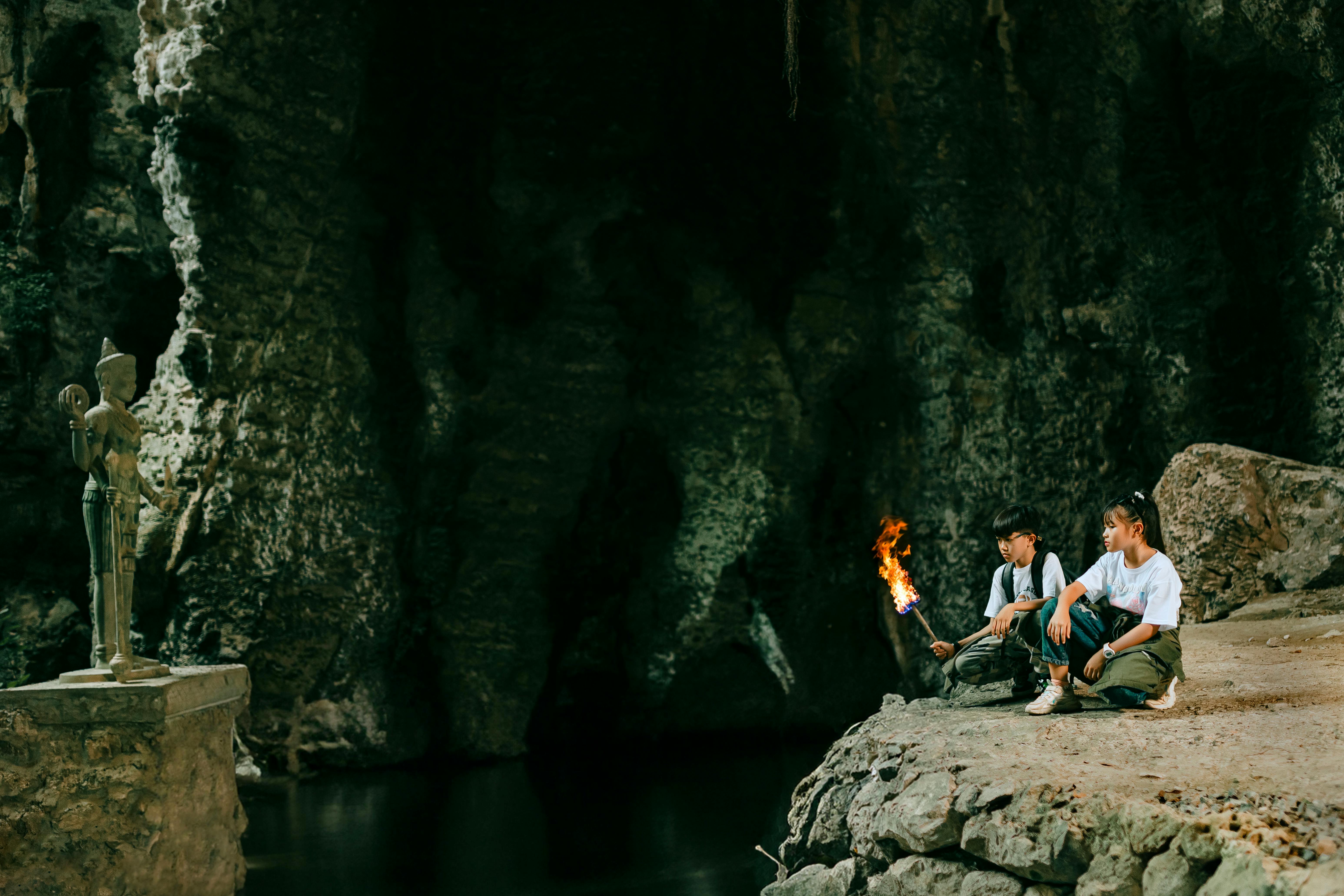 Girl and Boy with Torch in front of Religious Figure · Free Stock Photo