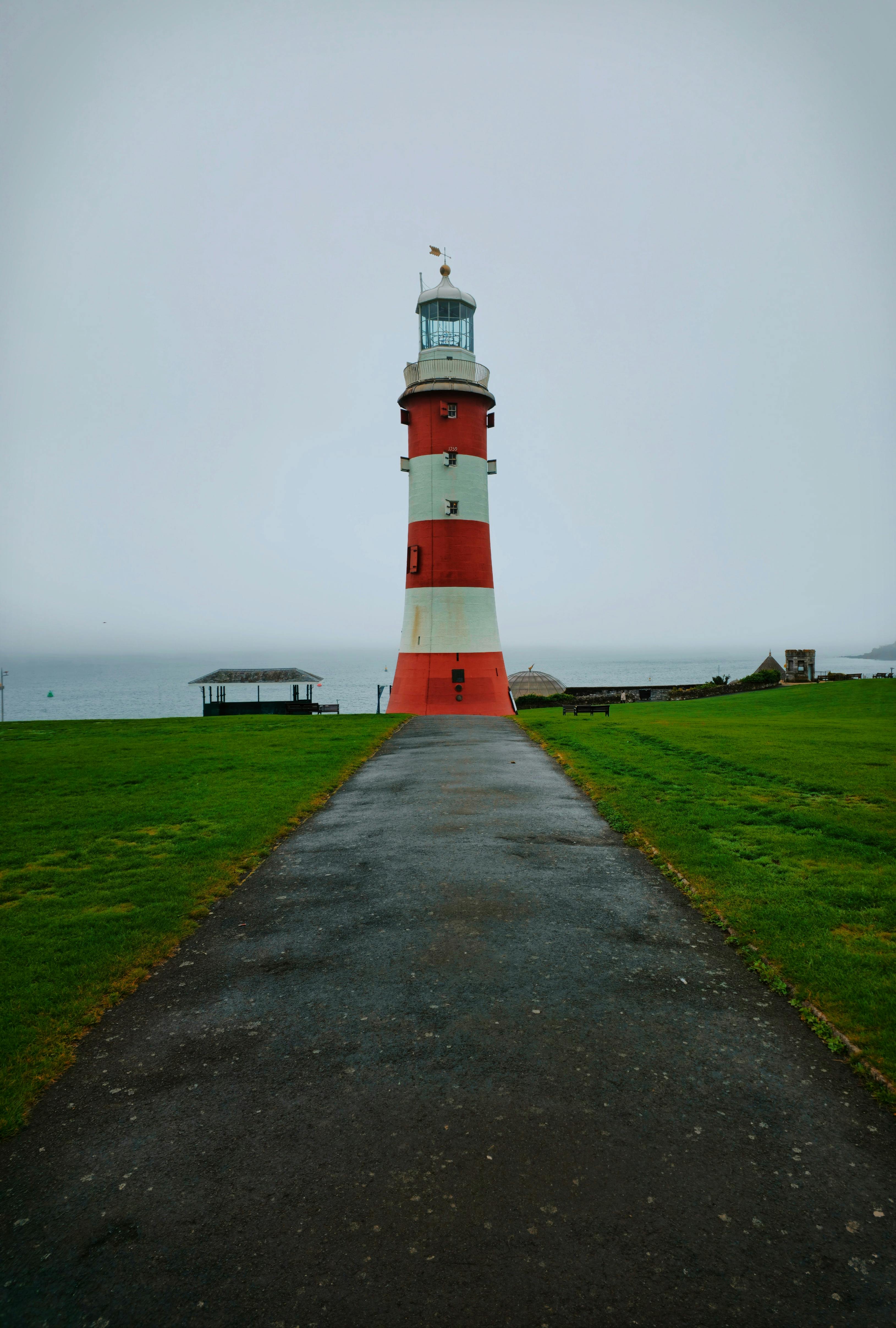 Walkway and a Lighthouse under an Overcast Sky · Free Stock Photo