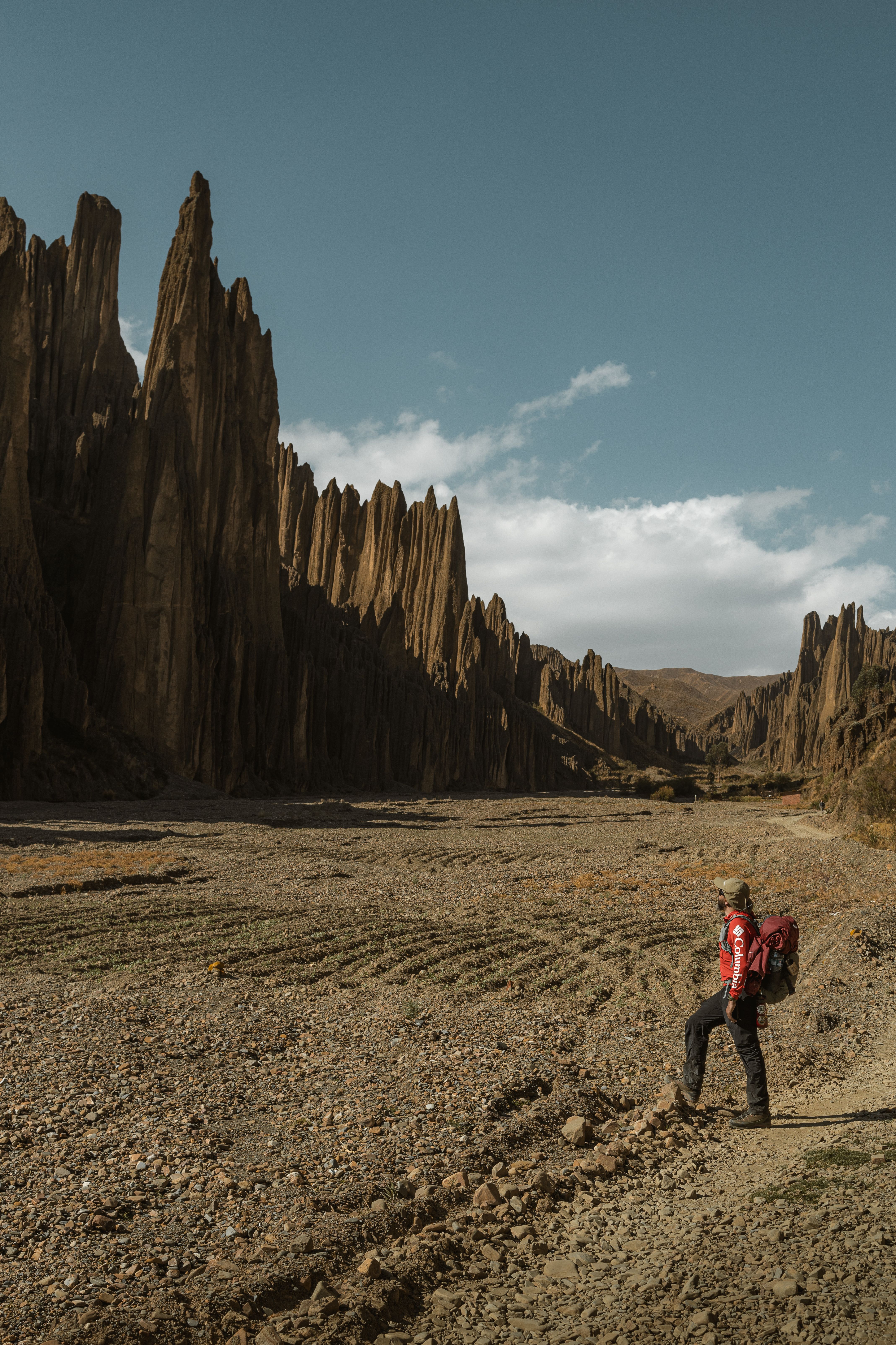 Man Standing near Sunlit Rock Formations · Free Stock Photo