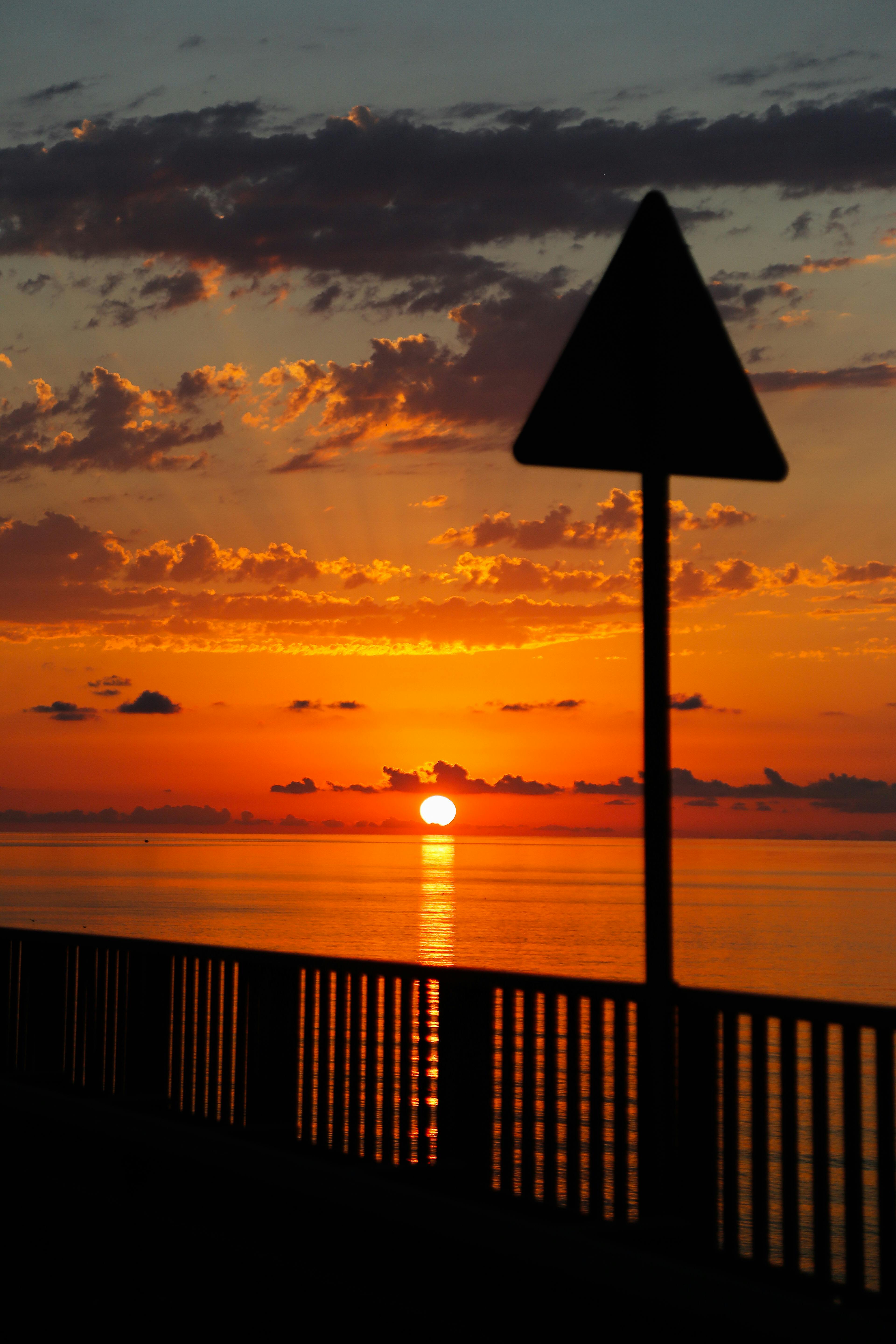 Road Sign on Sea Shore at Sunset · Free Stock Photo
