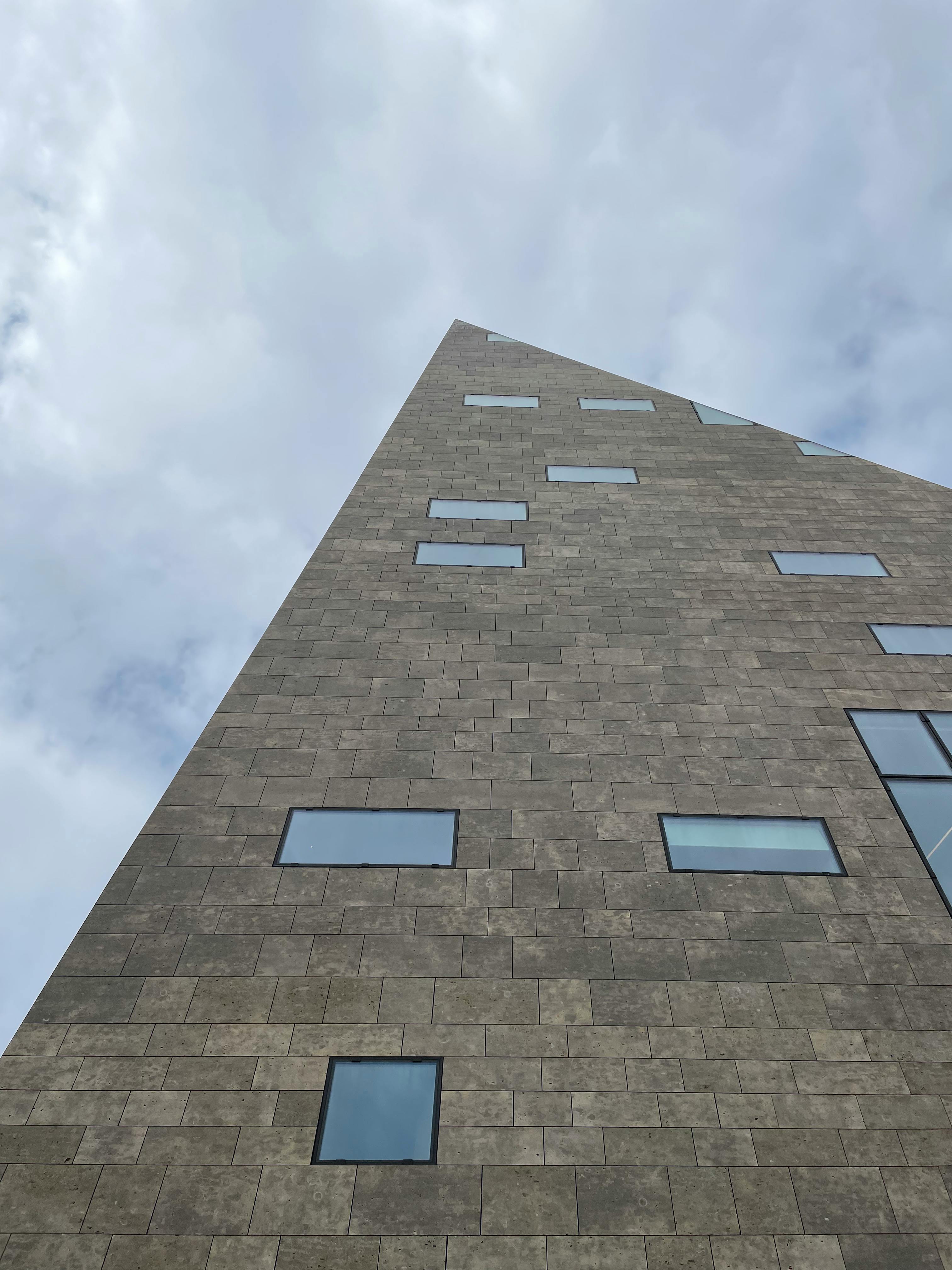 A tall building with windows and a sky · Free Stock Photo