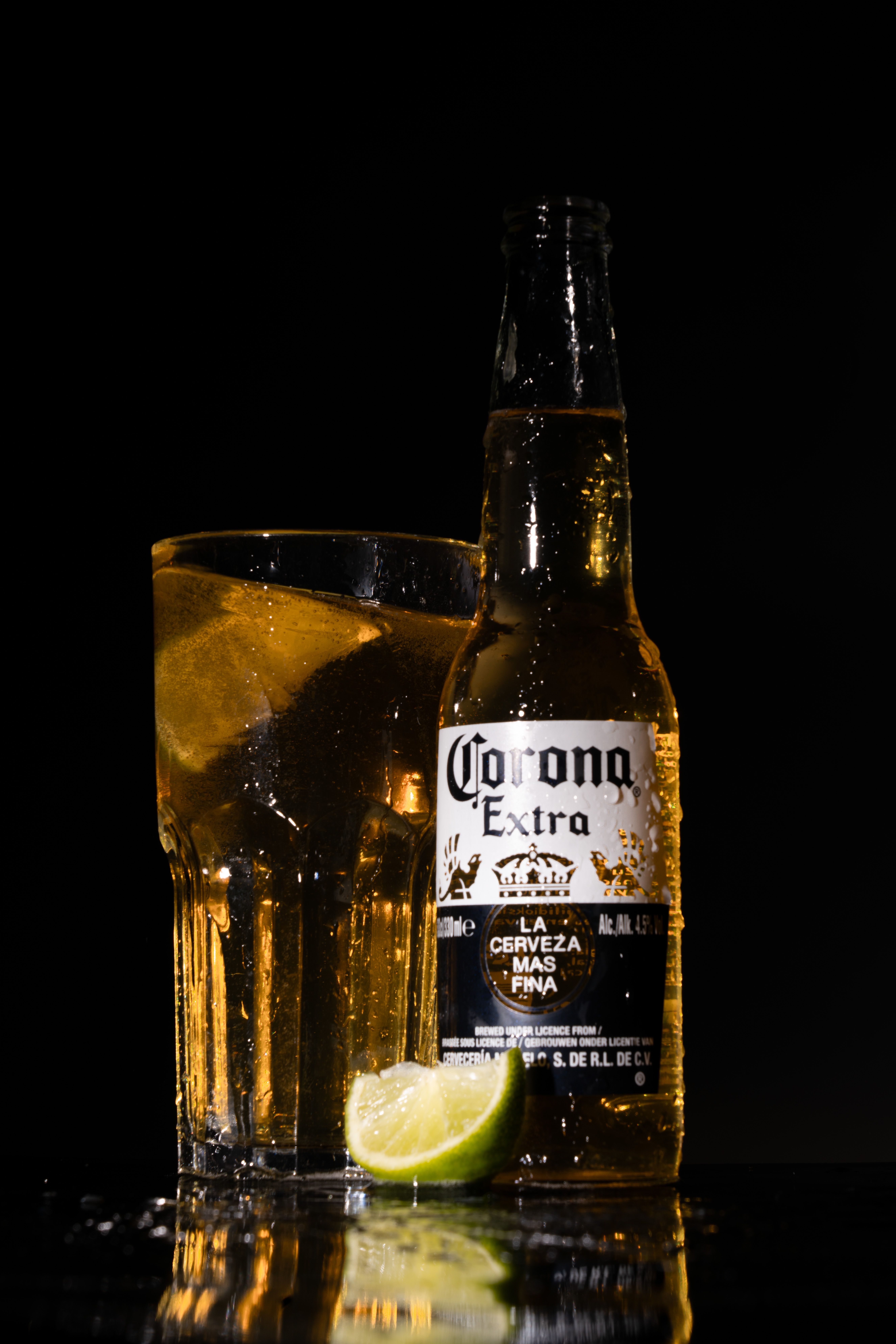 Corona Extra and Glass of Beer Against Black Background · Free Stock Photo