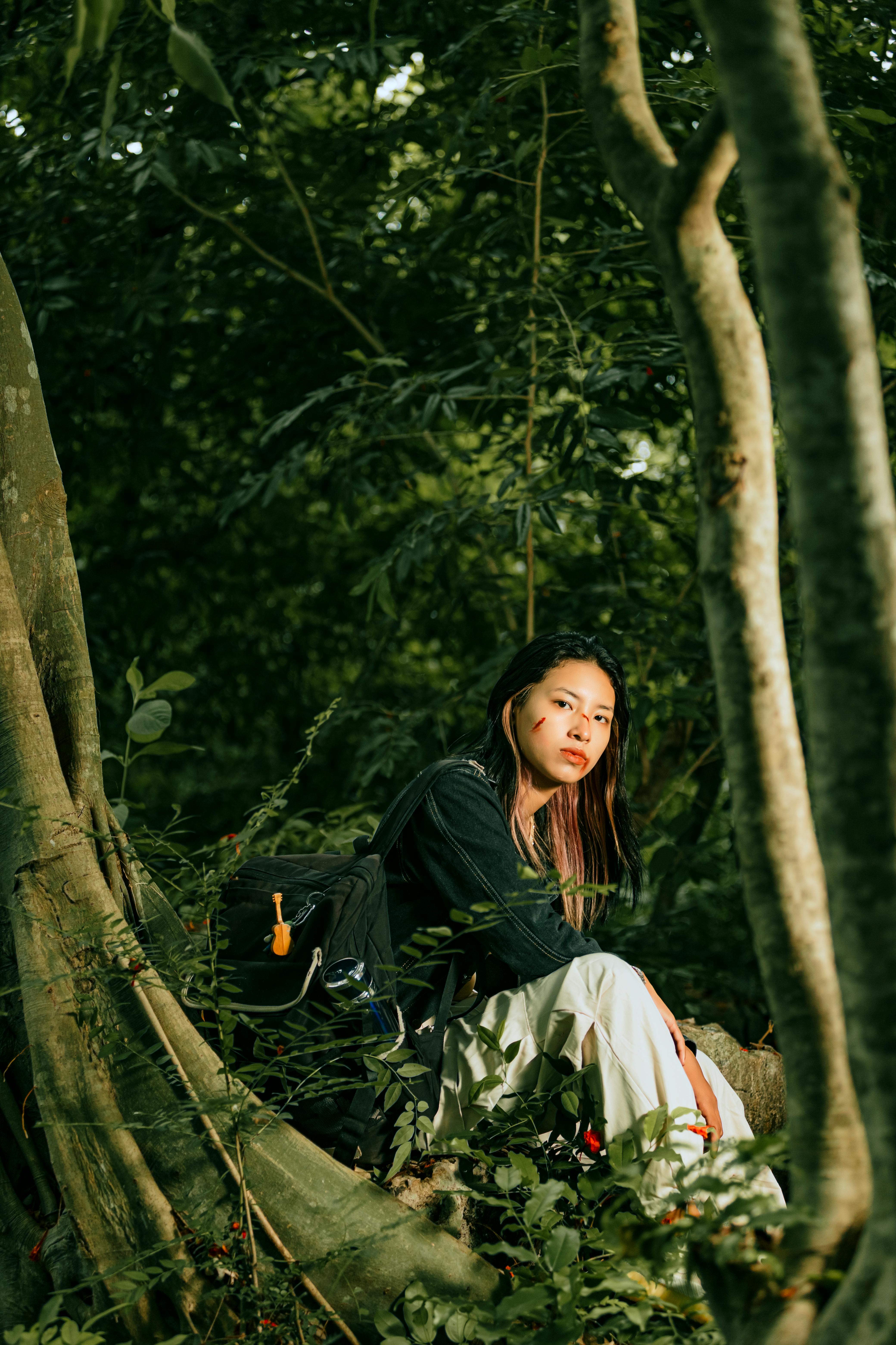 Brunette Woman in Denim Jacket Sitting on Tree · Free Stock Photo