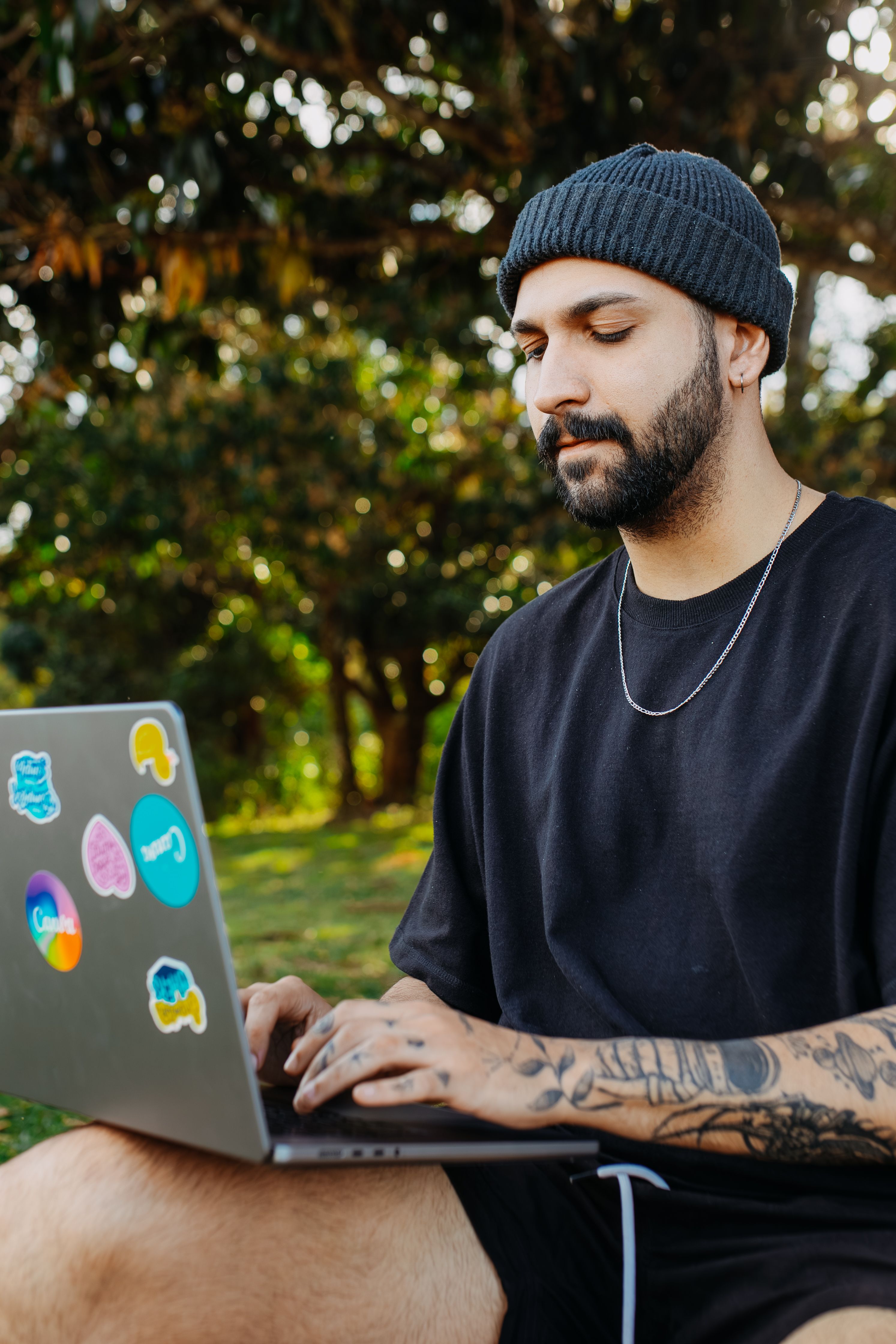 Man Sitting with Laptop with Stickers · Free Stock Photo