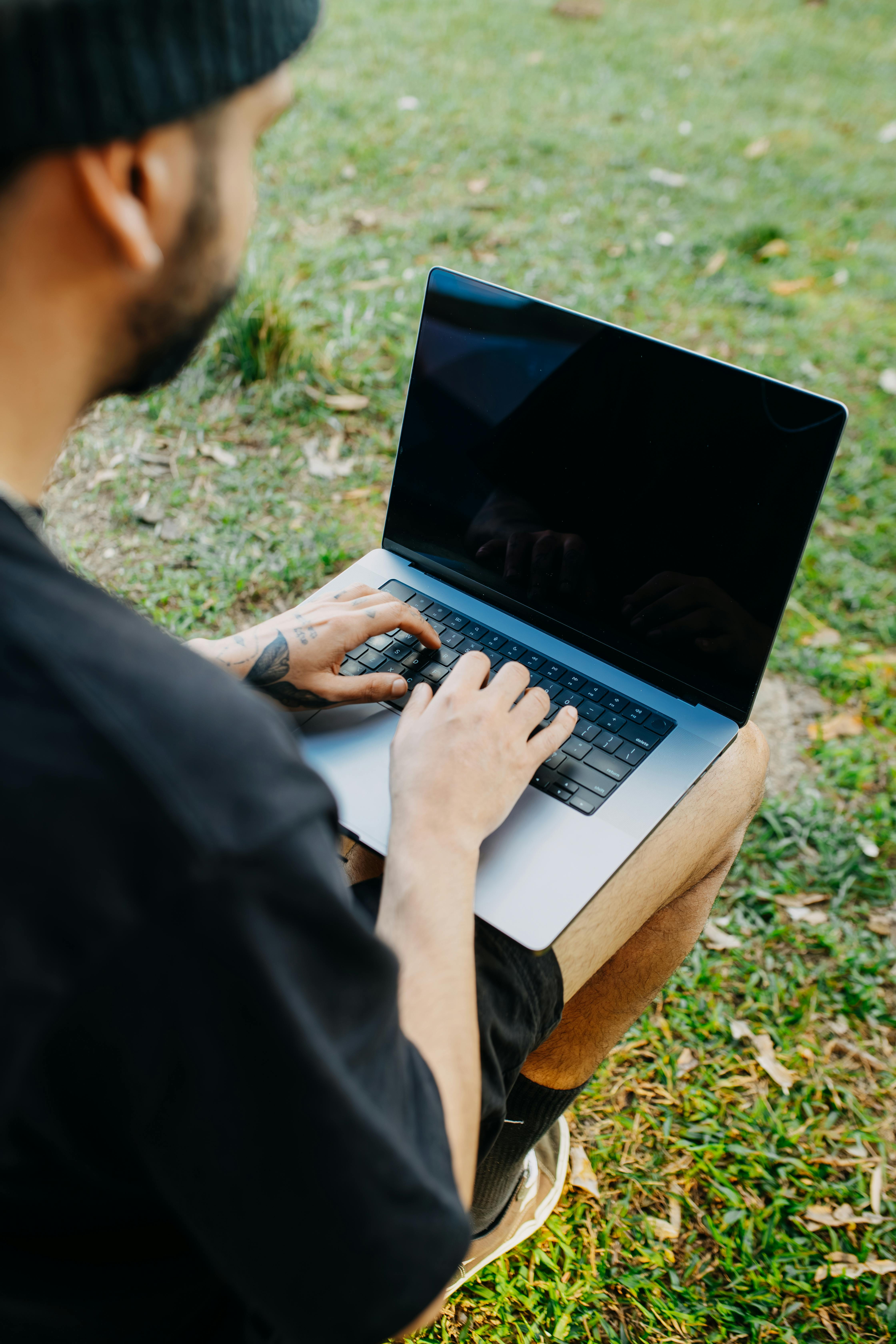 Sitting Man Holding Hands on Laptop · Free Stock Photo