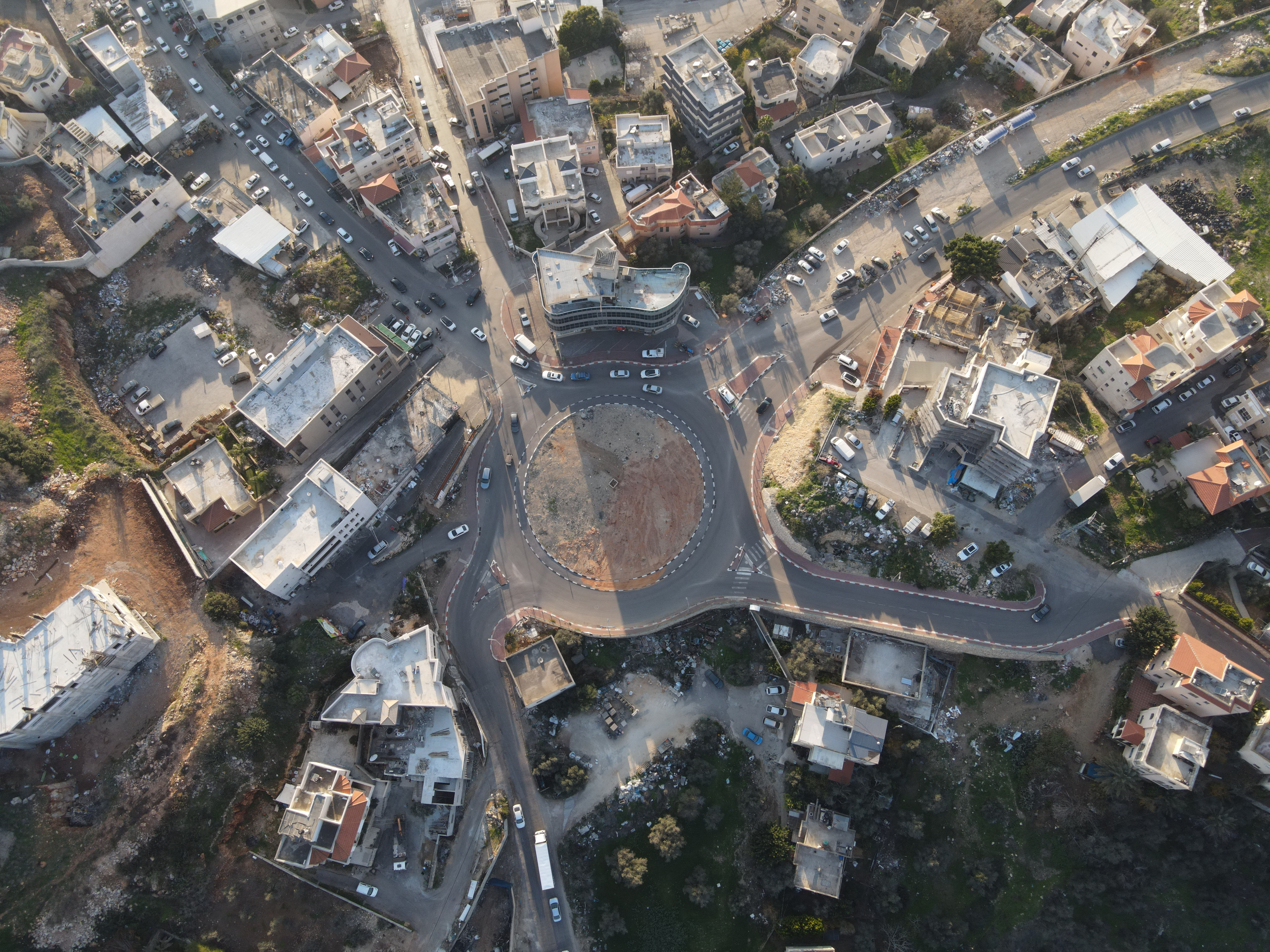 An aerial view of a city with a large roundabout · Free Stock Photo