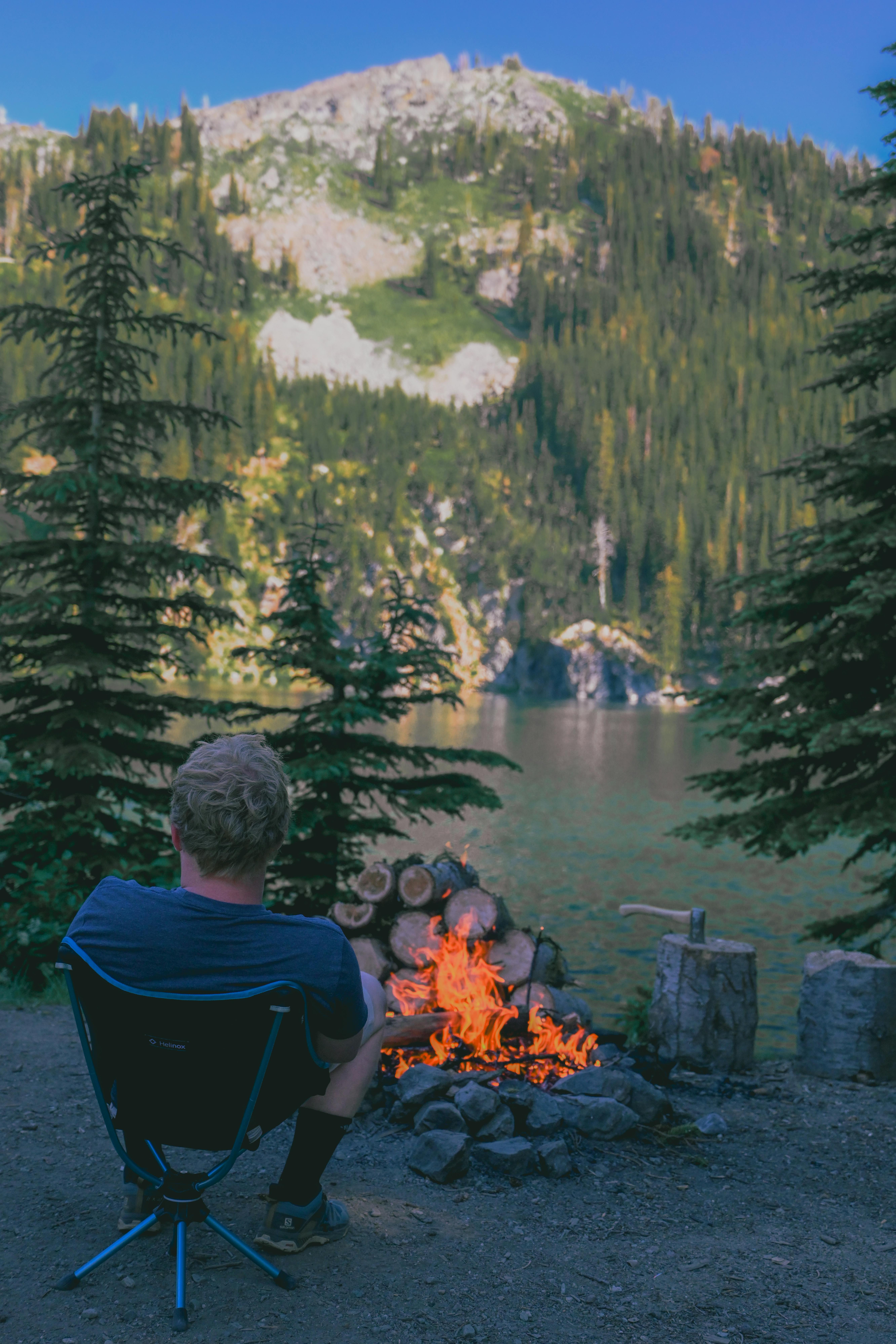 Man Sitting by the Fire in the Valley · Free Stock Photo