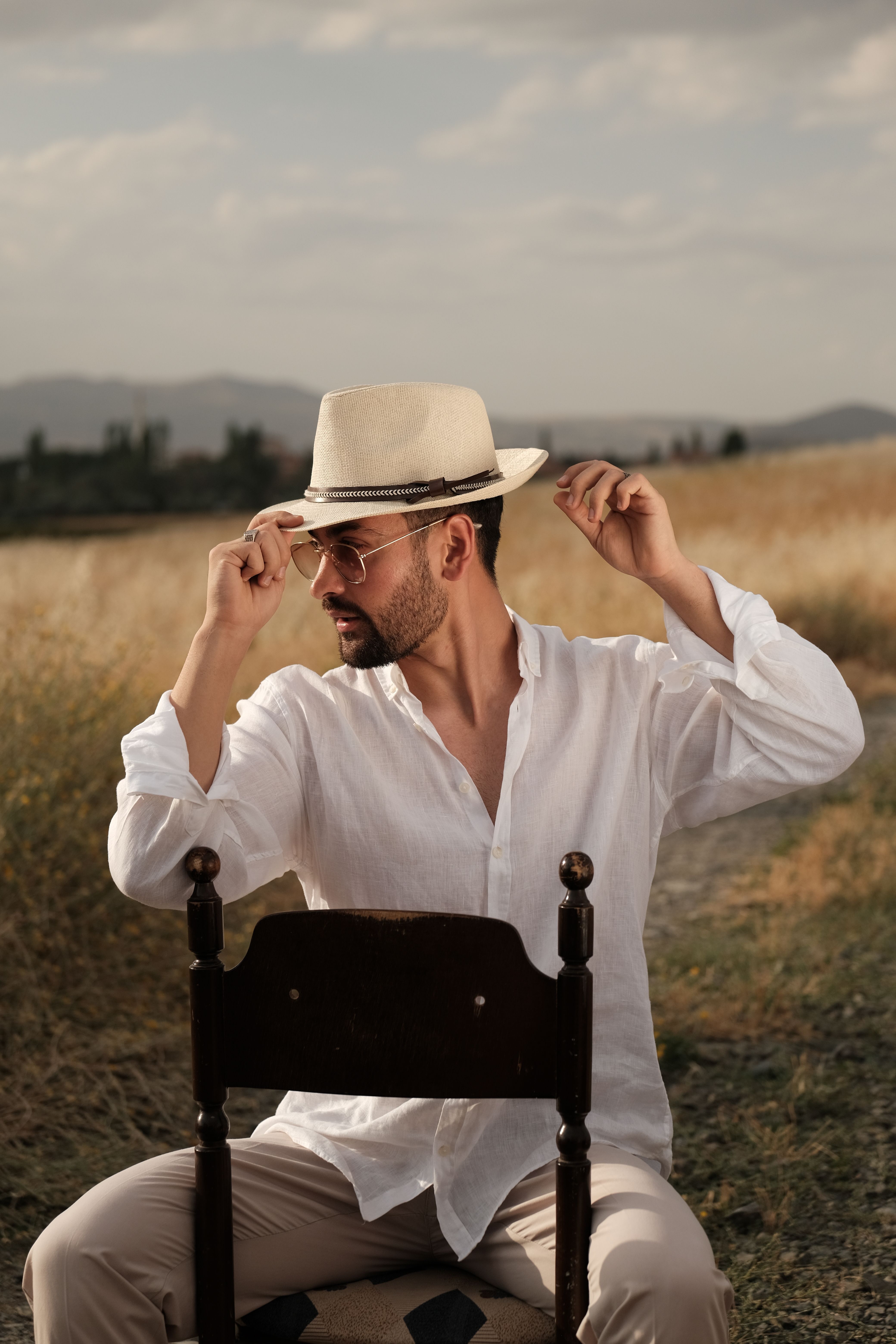 Man in Shirt and Hat Sitting on Chair · Free Stock Photo