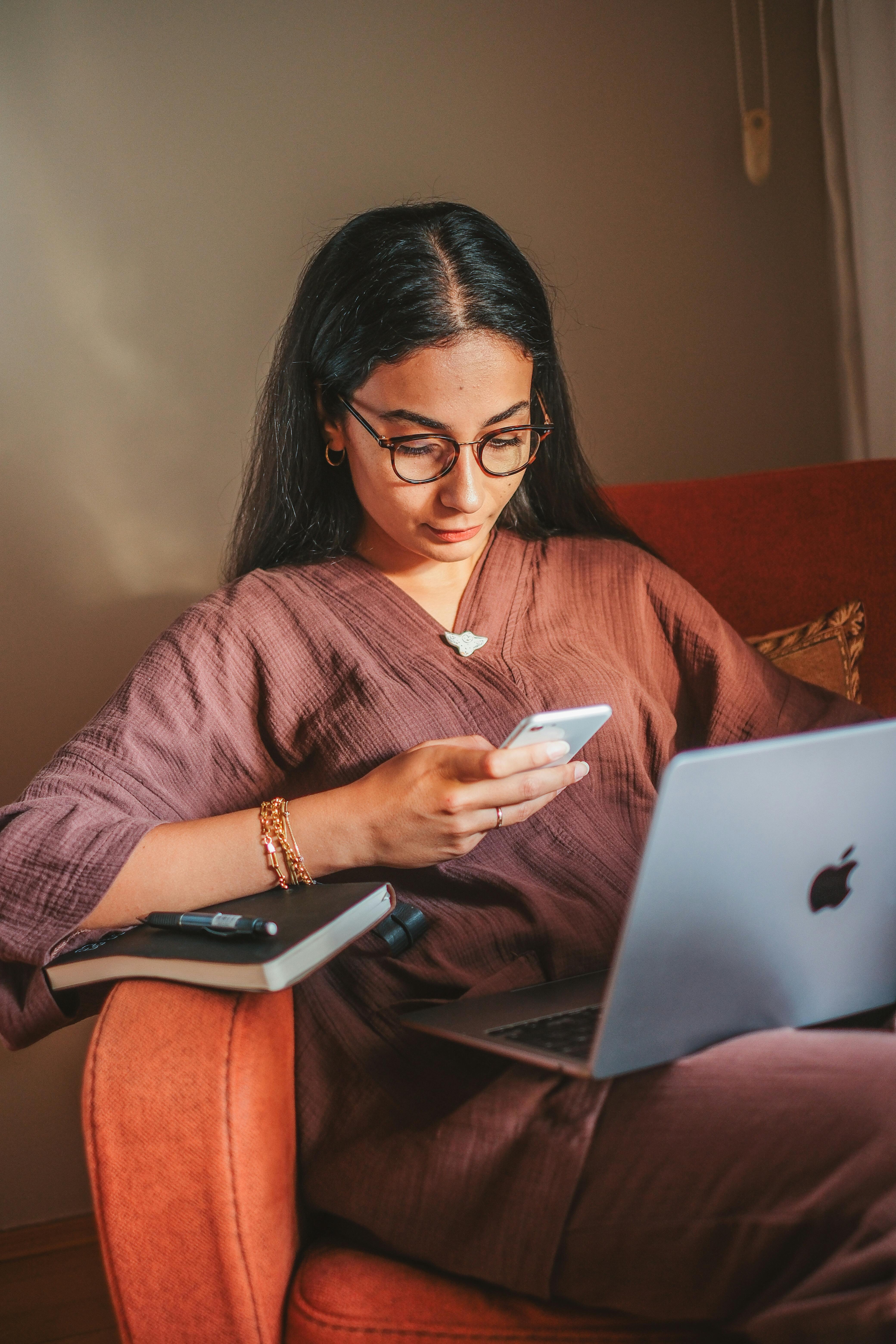 Woman Sitting and Using Cellphone and Laptop · Free Stock Photo