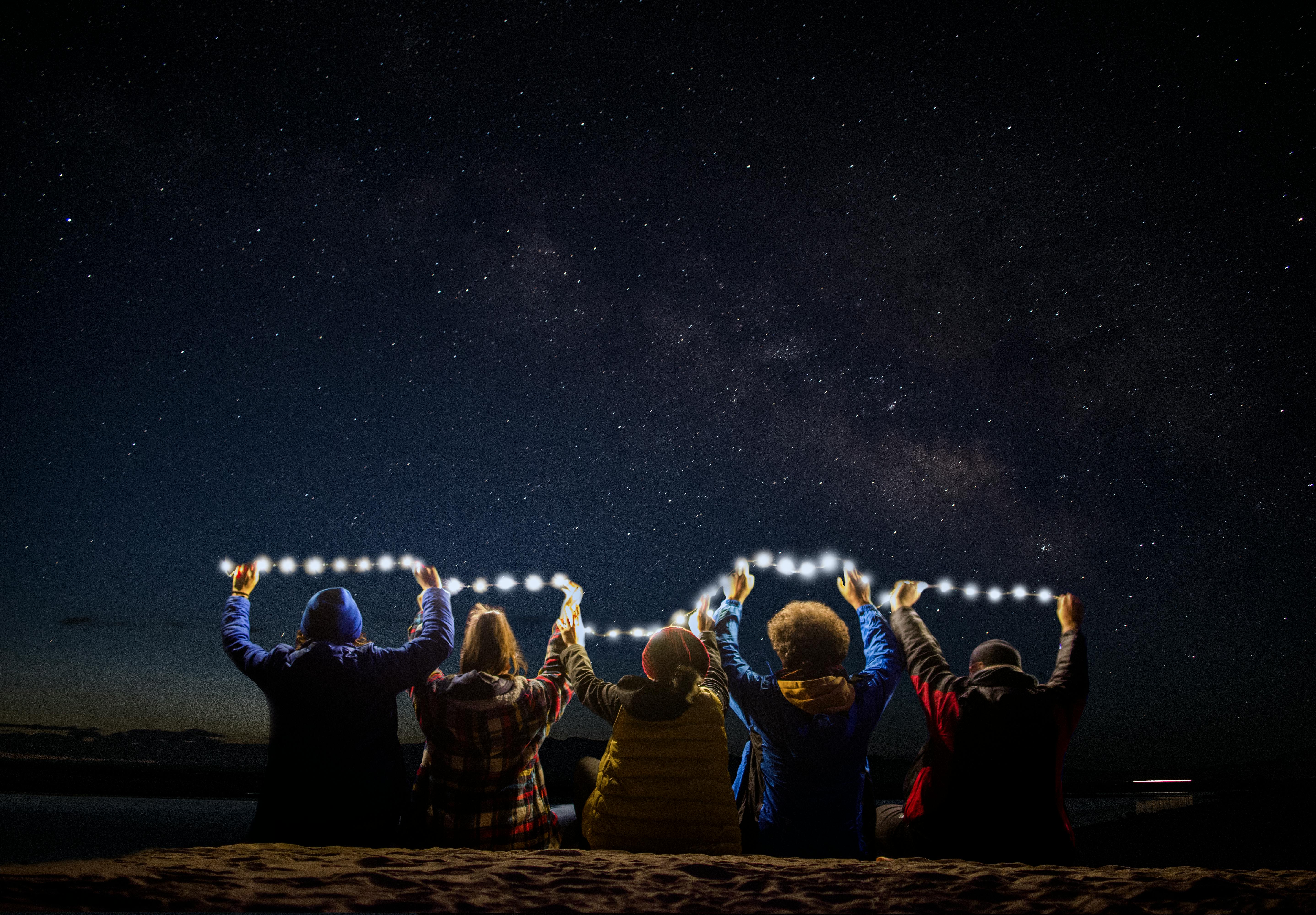People Sitting Together with Lights at Night · Free Stock Photo