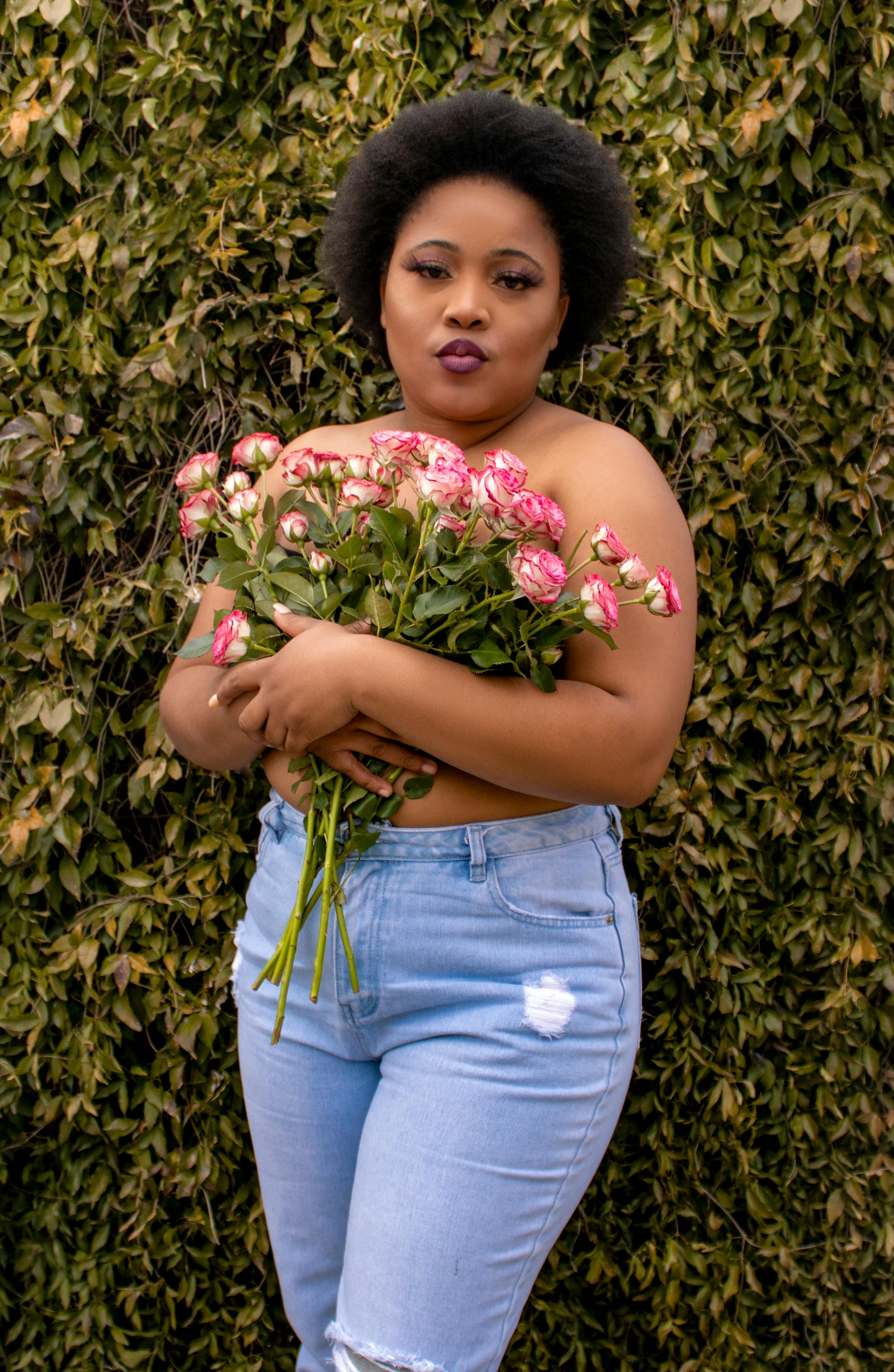 Young Woman with Afro Hairdo Holding a Bunch of Rose Flowers · Free ...