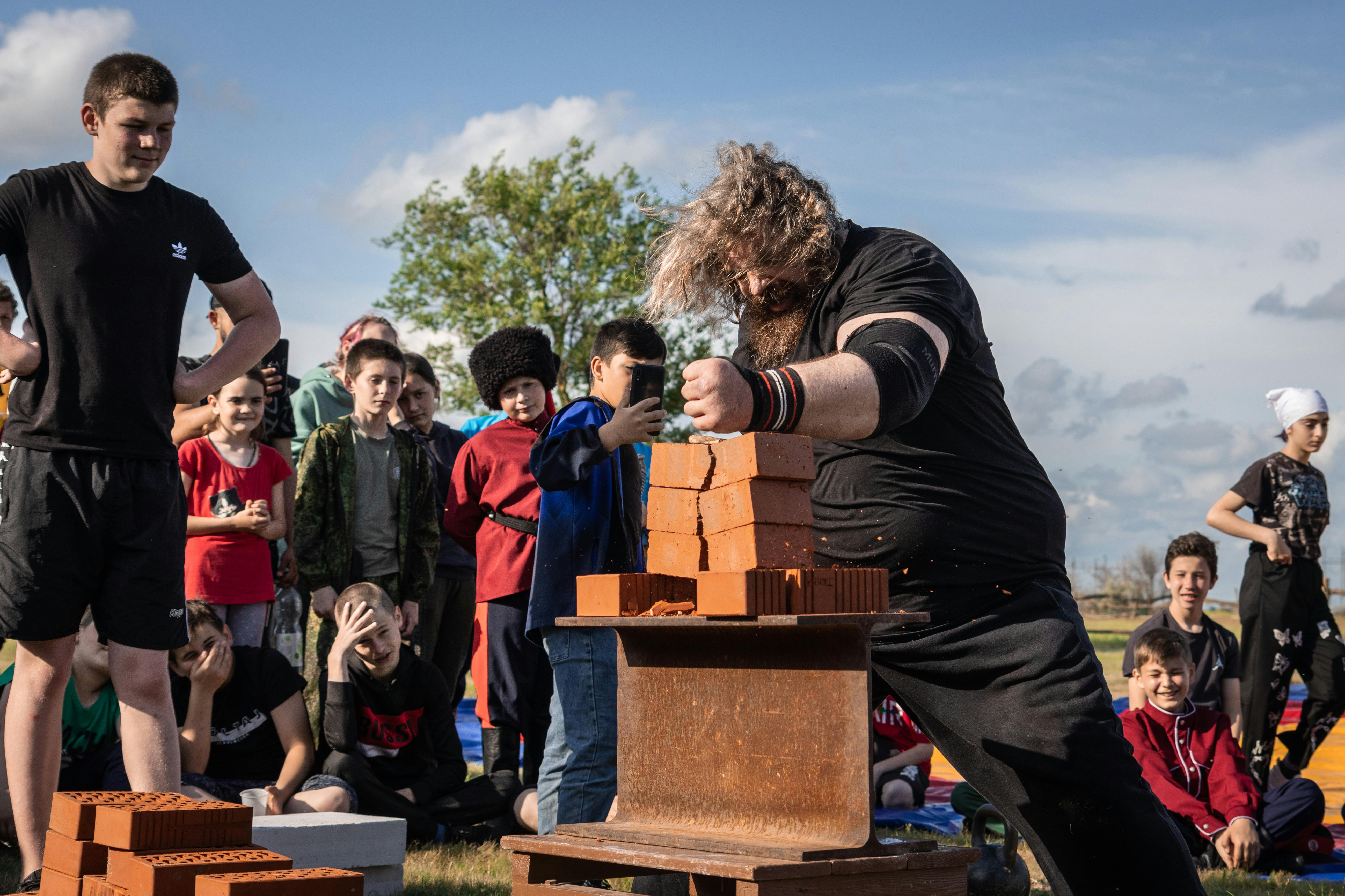 Black and White Photo of a Muscular Man Cracking Bricks and Crowd ...