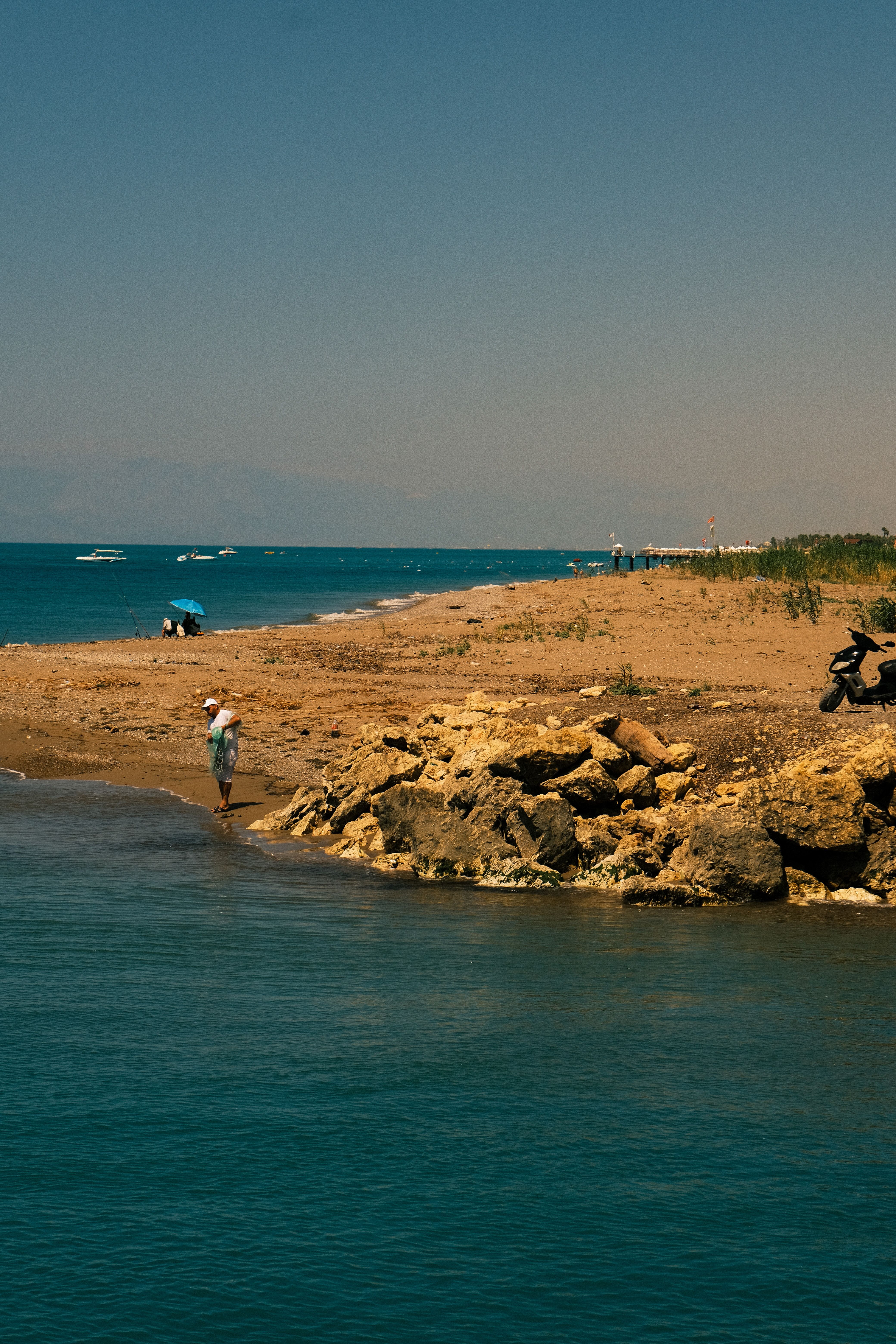 Dark Turquoise Sea and a Yellow Shore with Stones · Free Stock Photo