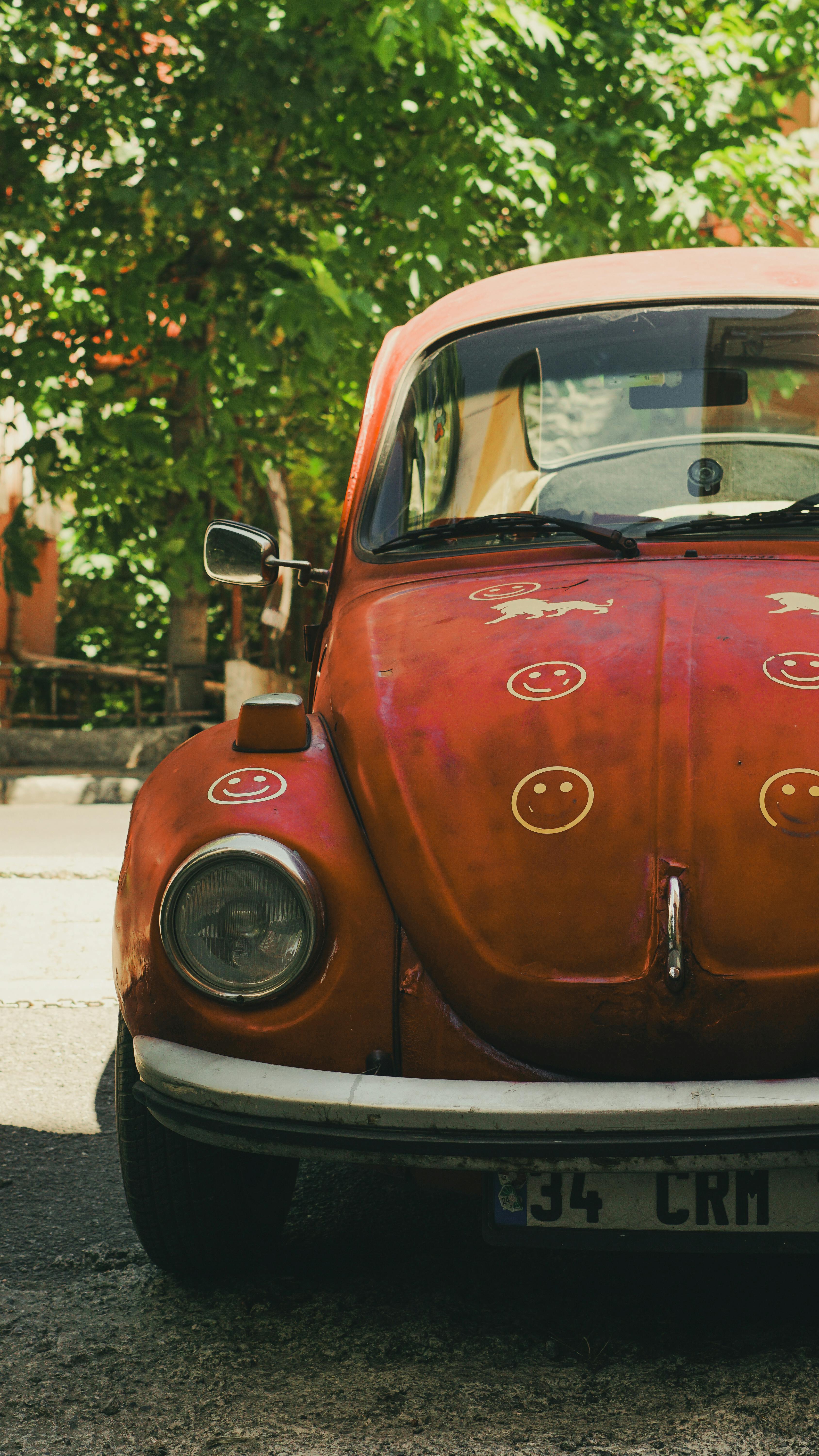 A red vw beetle with smiley faces painted on it · Free Stock Photo