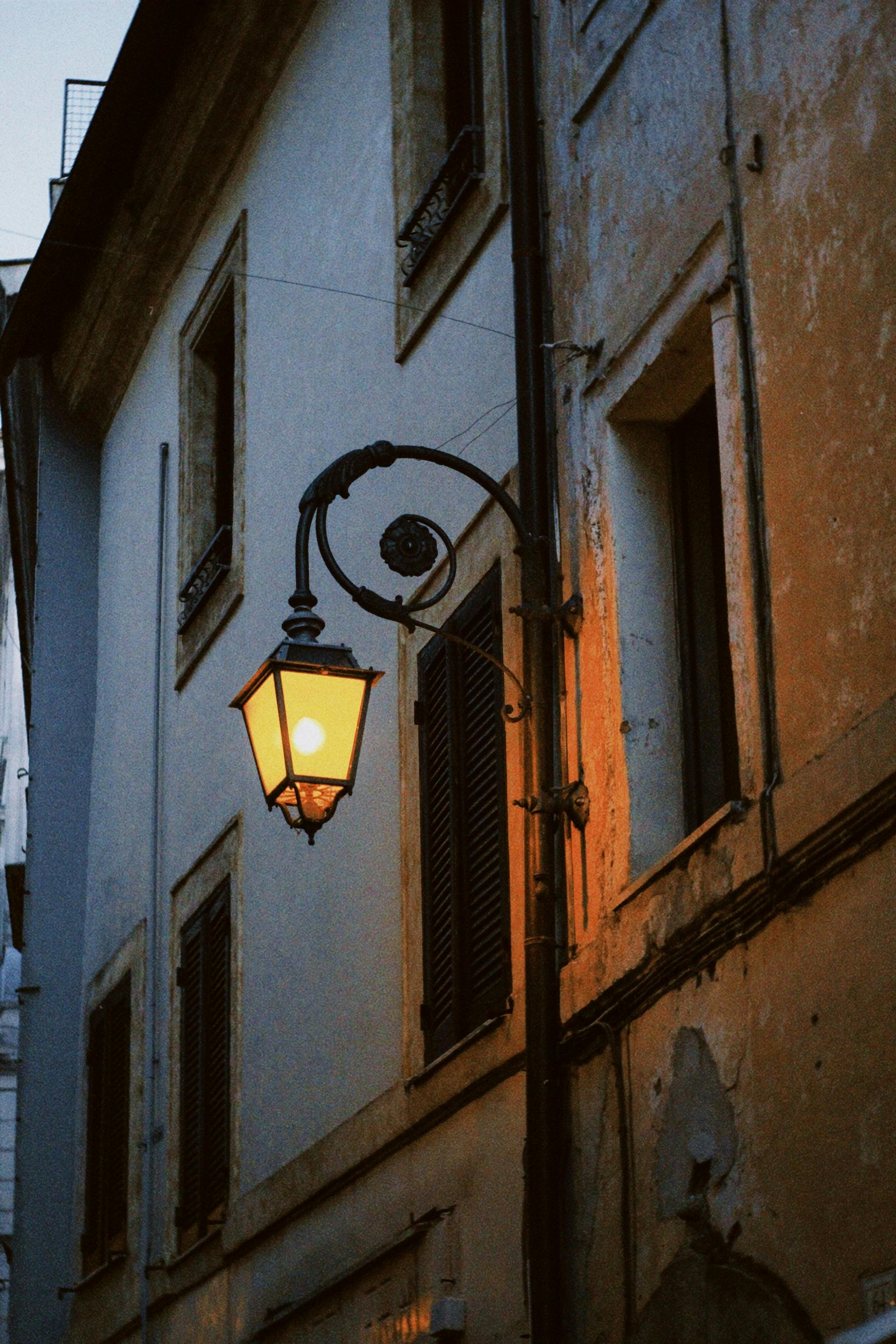 Old-Fashioned Street Light Glowing over a Street · Free Stock Photo