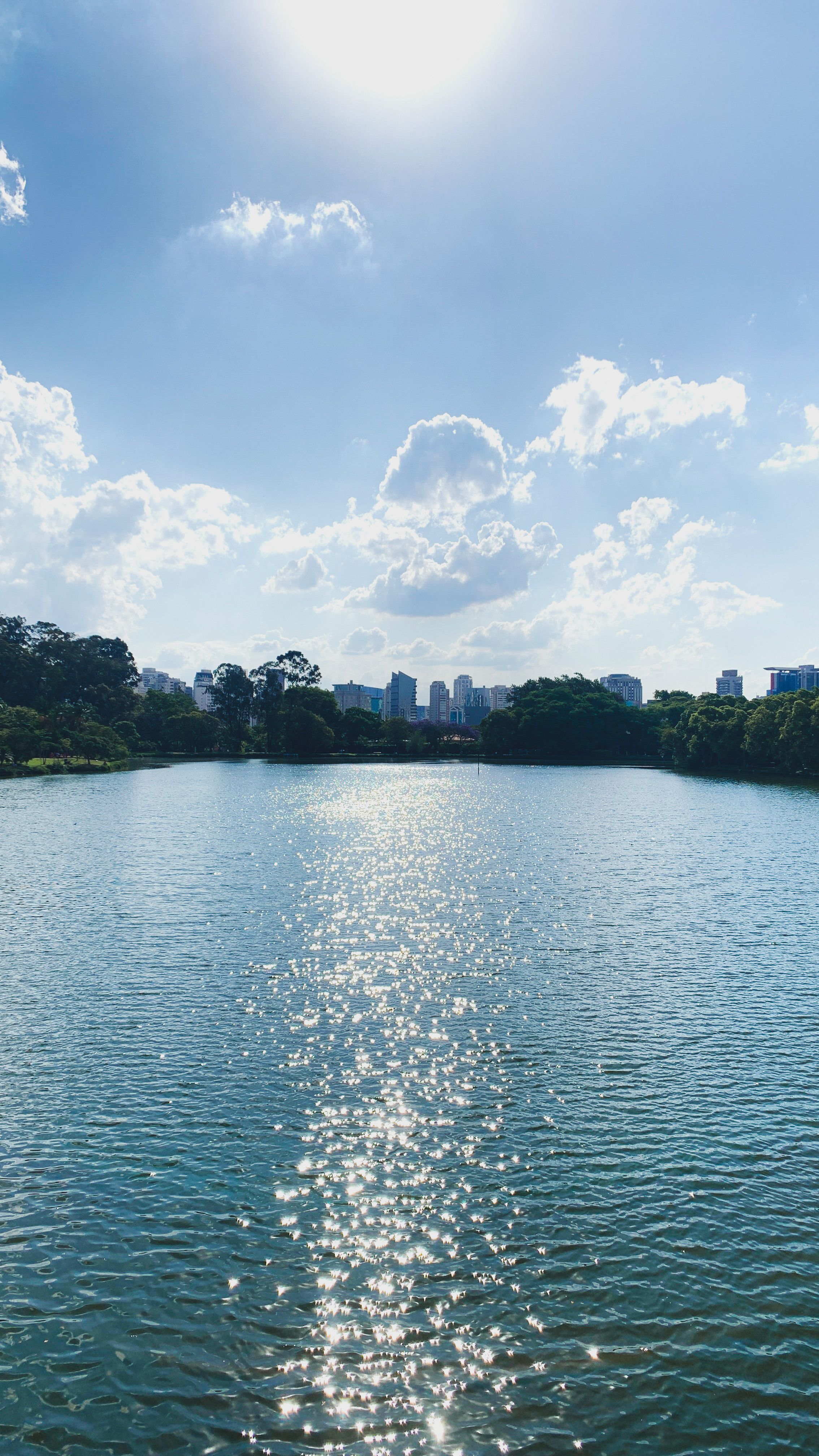 Sunlight over Lake with City behind · Free Stock Photo
