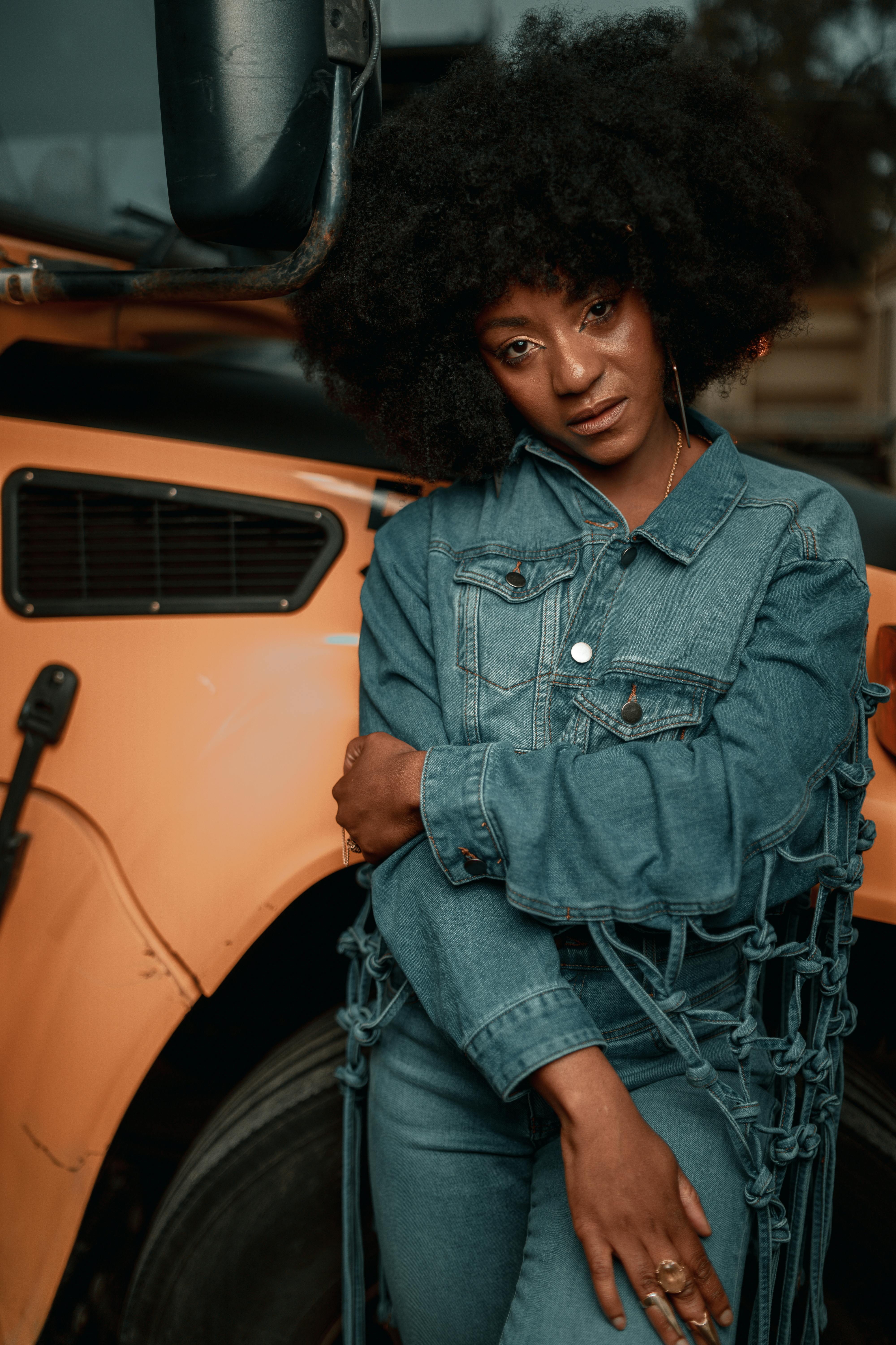 A woman with an afro wearing a denim jacket · Free Stock Photo