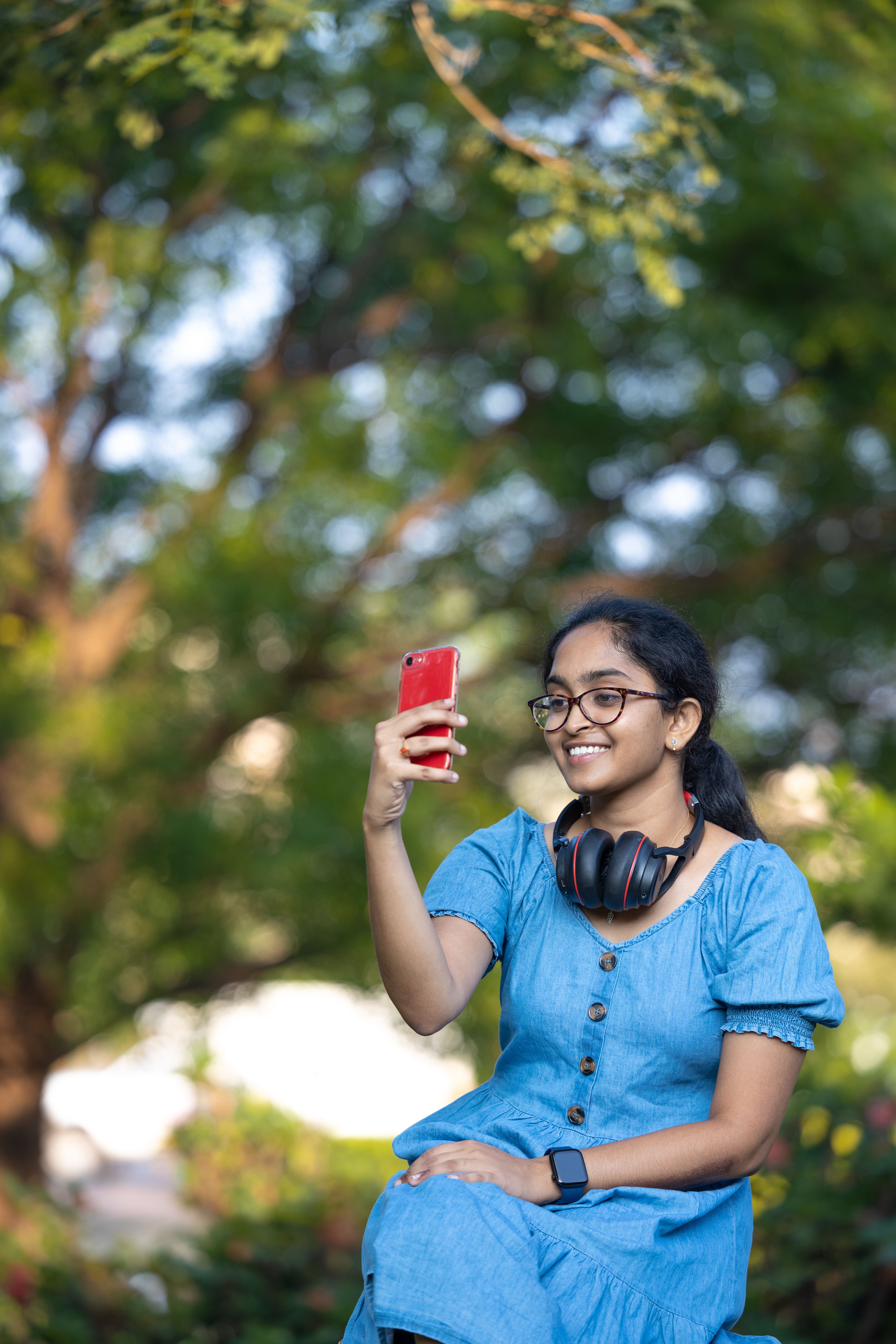Woman in Blue Dress Sitting and Taking Selfie · Free Stock Photo