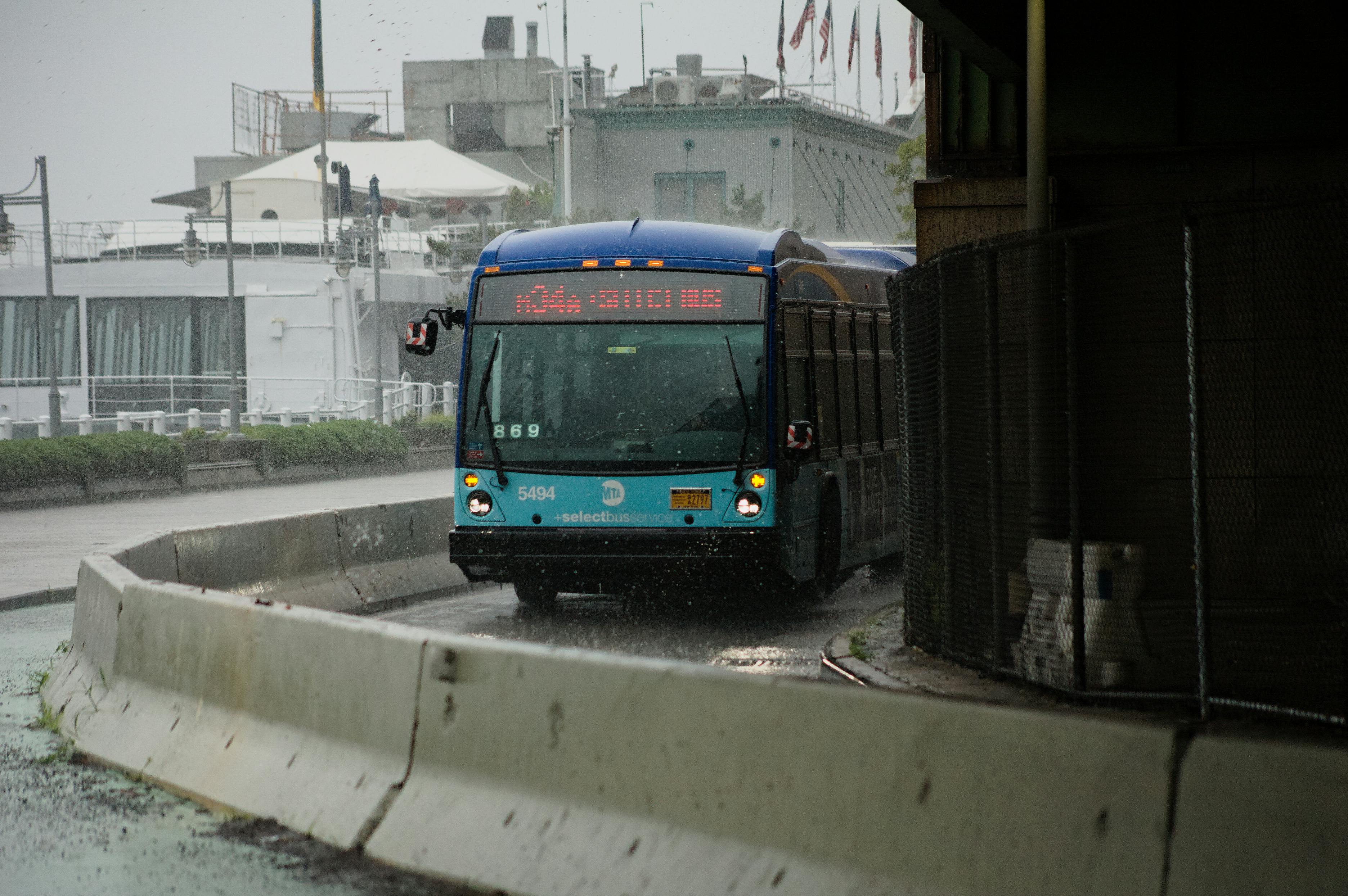 A bus is driving down a street in the rain · Free Stock Photo