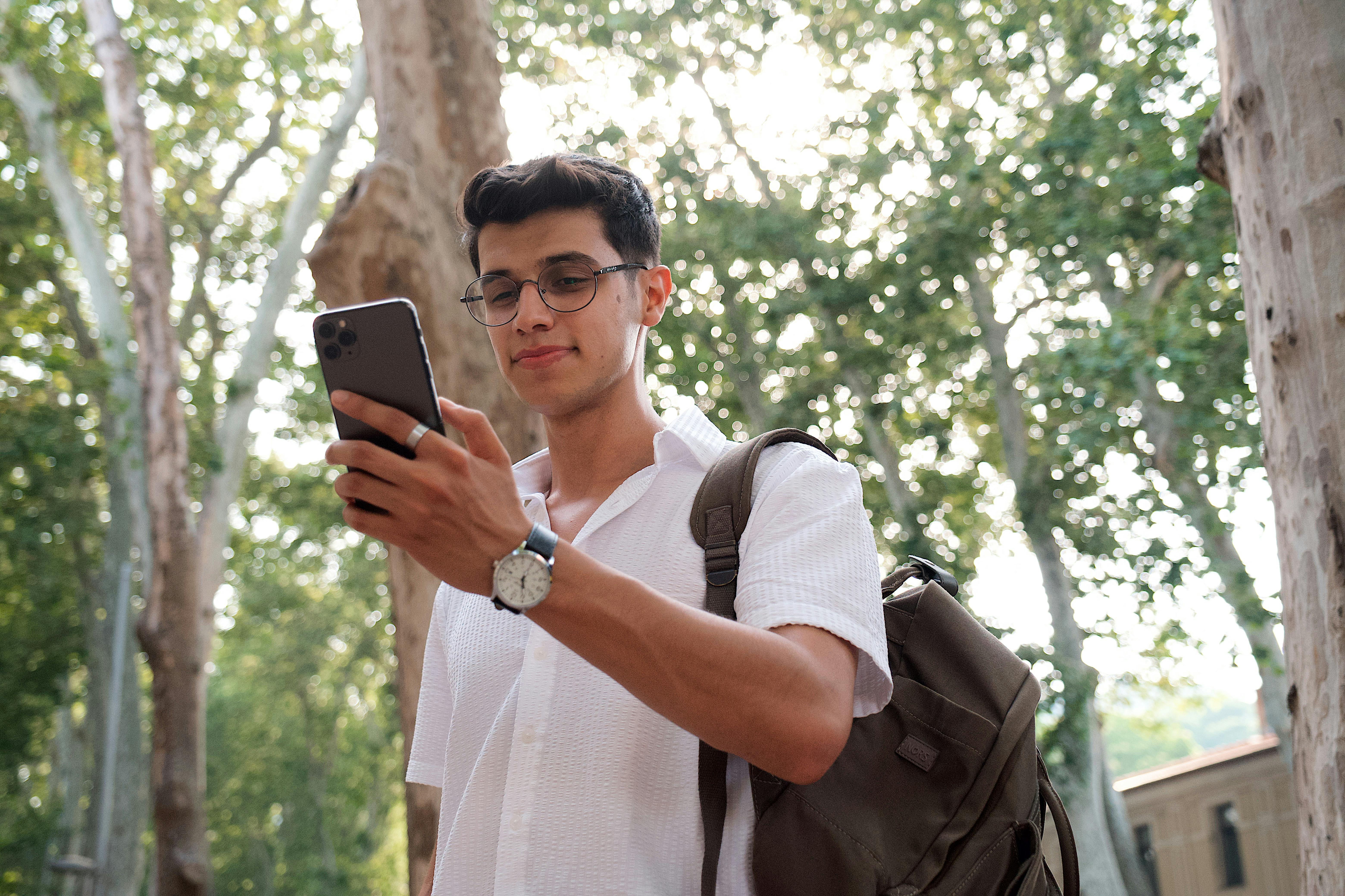 Man Using Phone Among Trees · Free Stock Photo