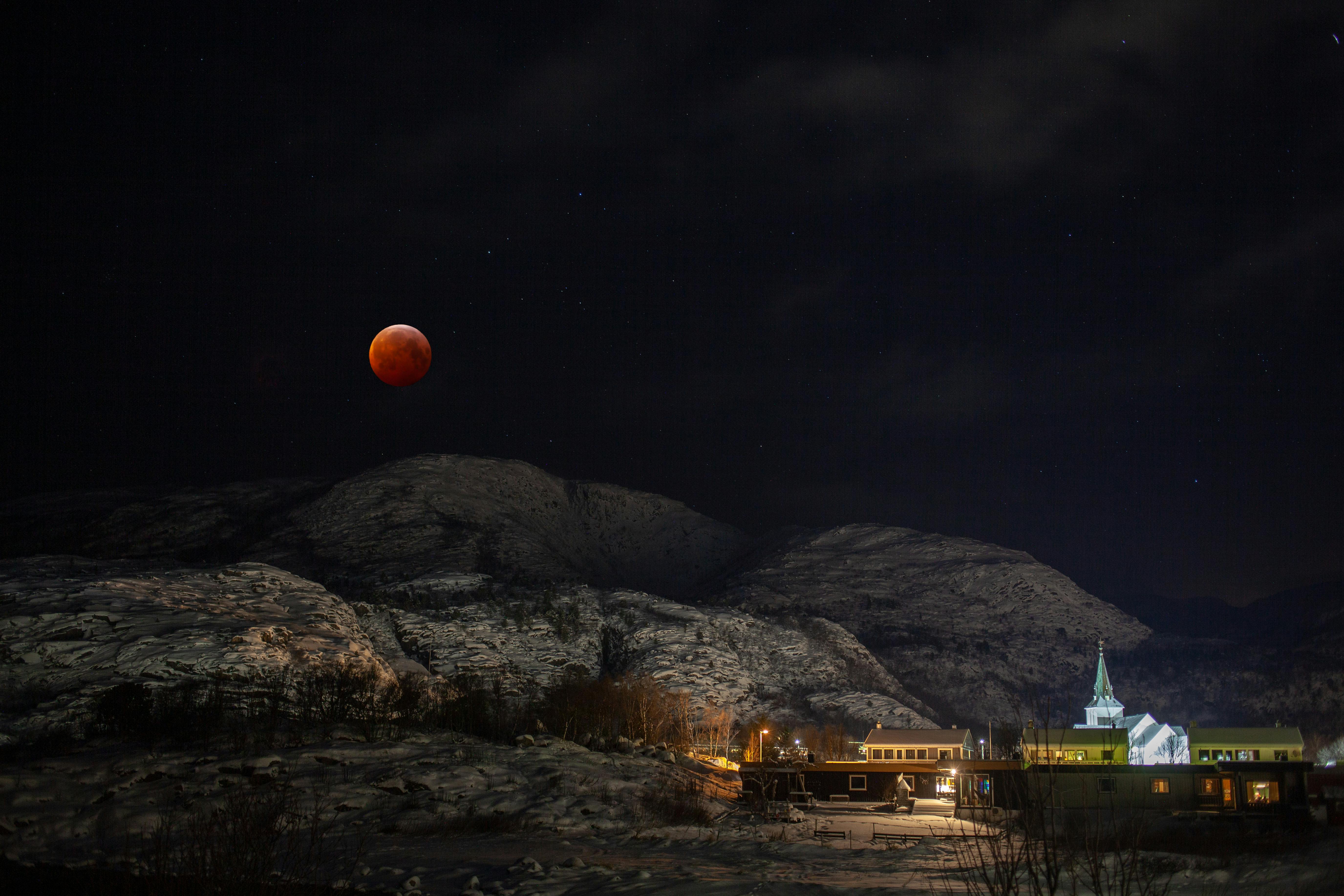 A red moon over a mountain town with a church in the background · Free ...