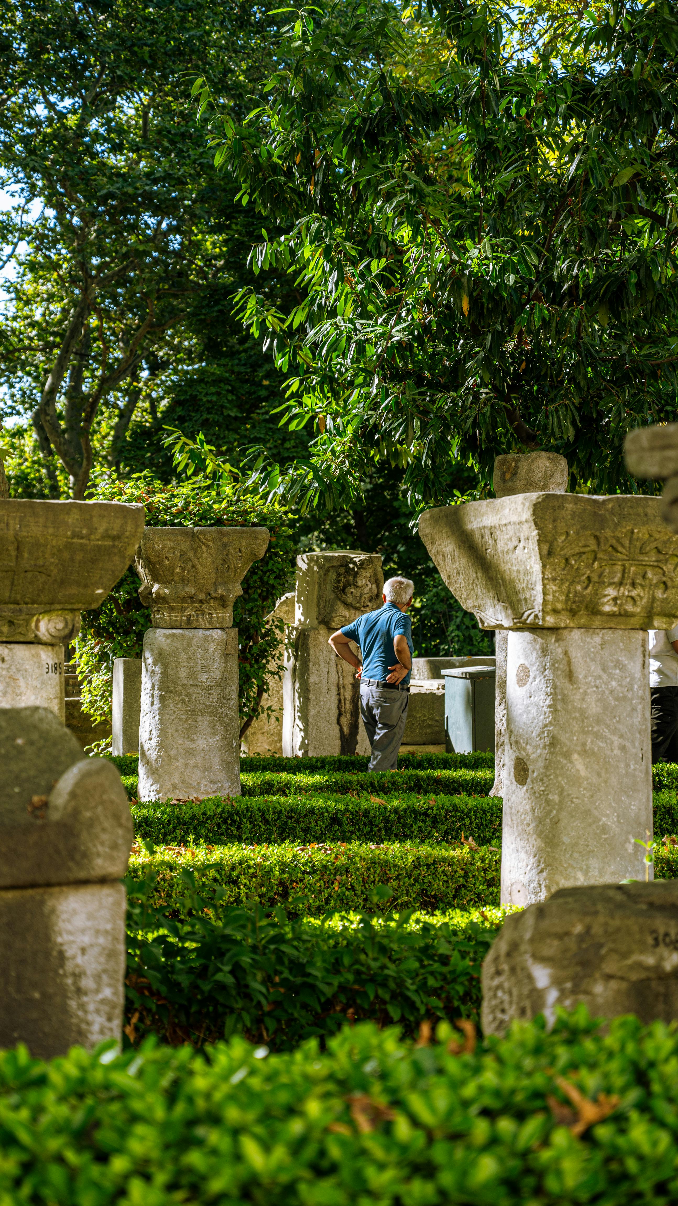 Man Walking between the Tombstones in a Cemetery · Free Stock Photo