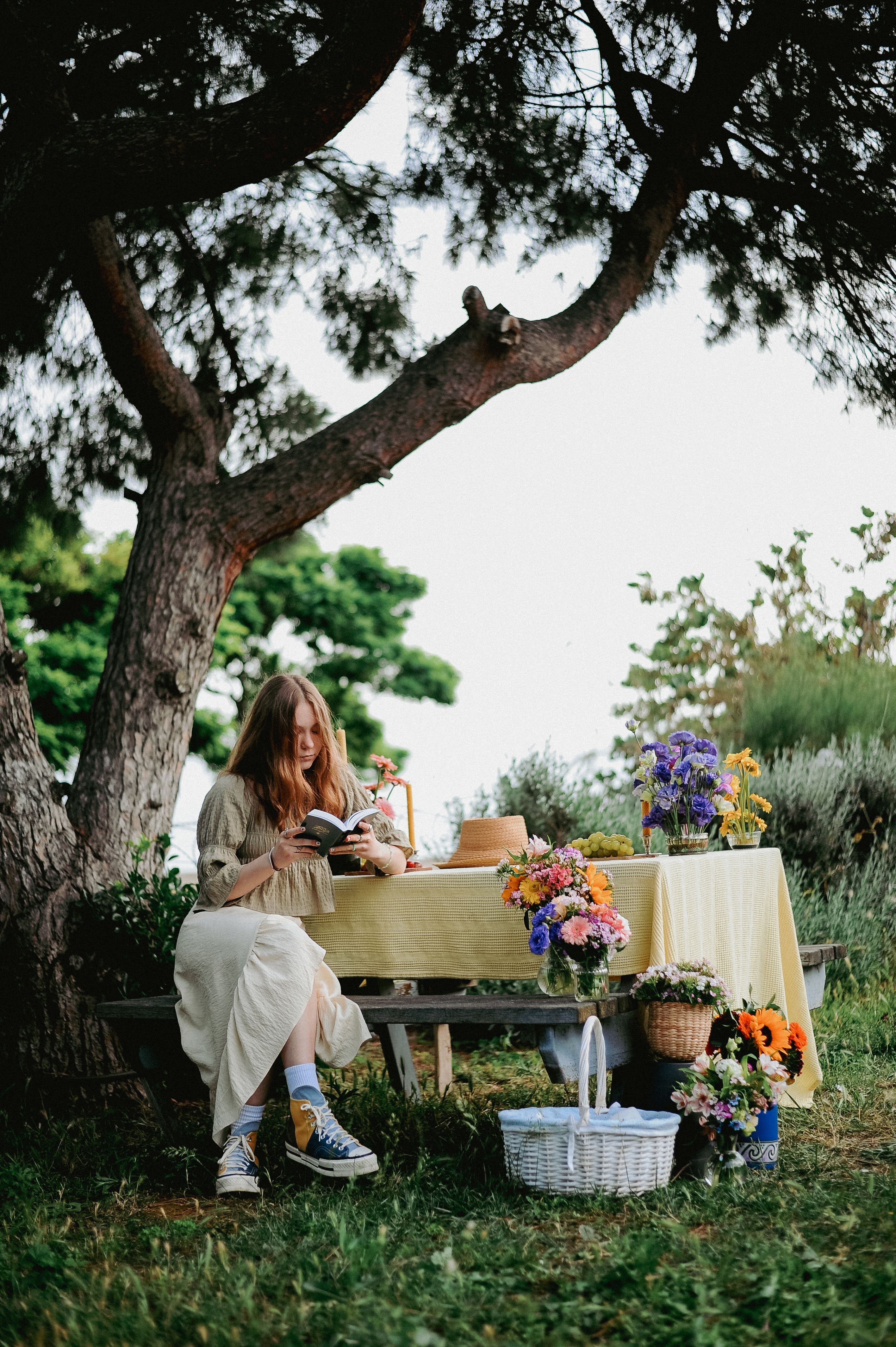 Young Girl Reading at a Picnic Table Decorated with Blooming Flowers ...