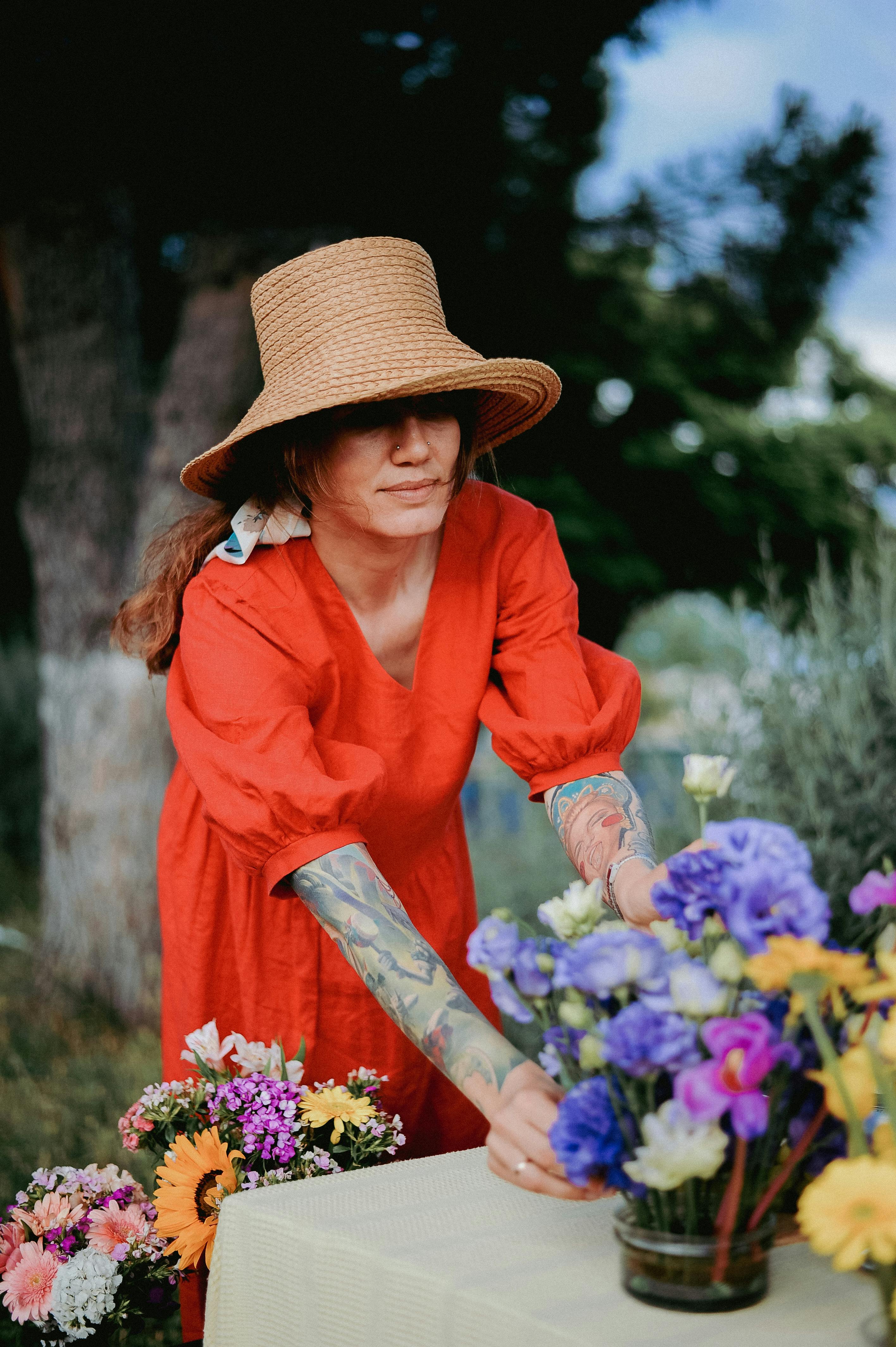 Woman Putting Flowers on the Table in the Garden · Free Stock Photo