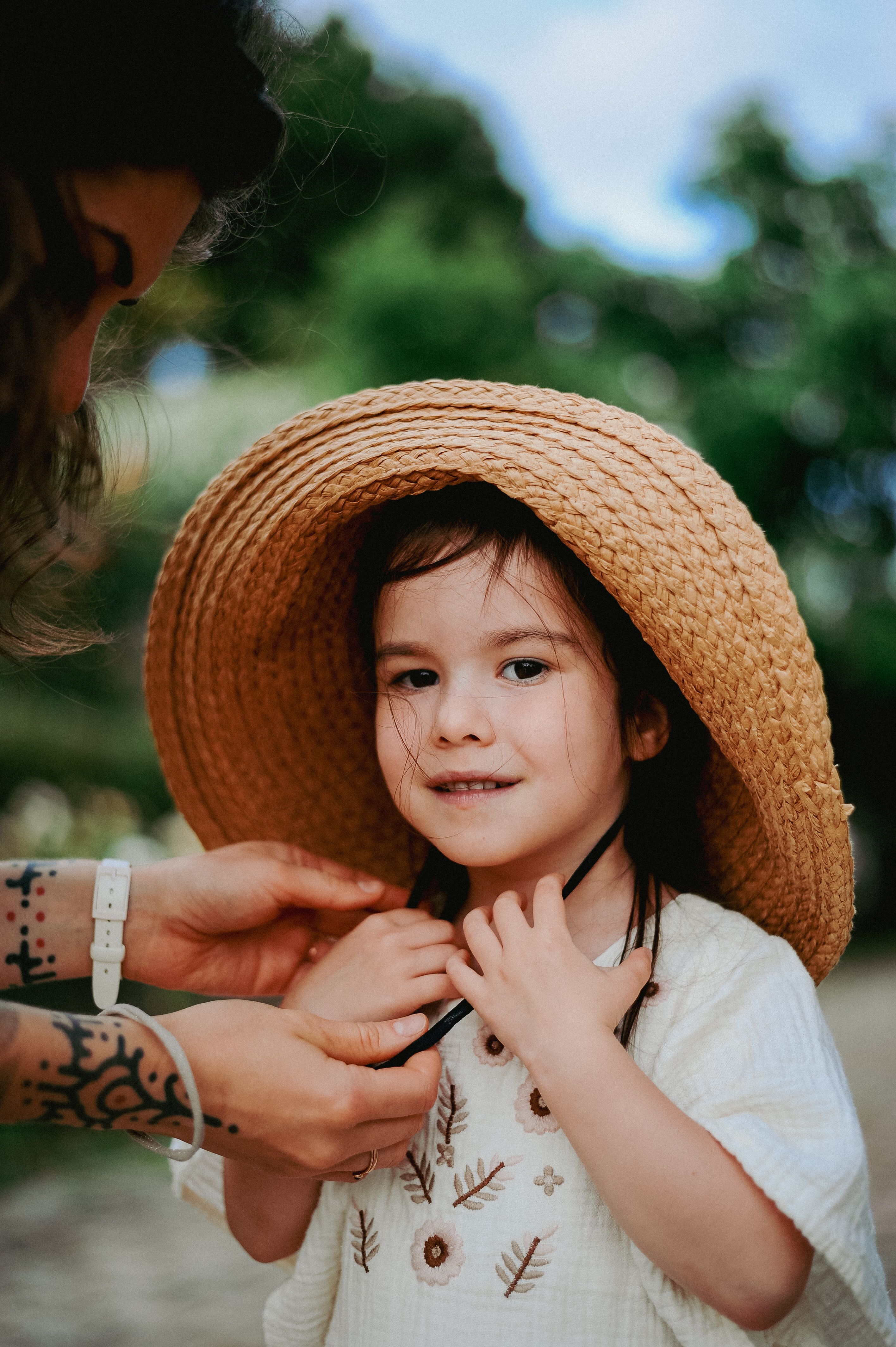 Woman Helping a Little Girl with Putting on a Hat · Free Stock Photo
