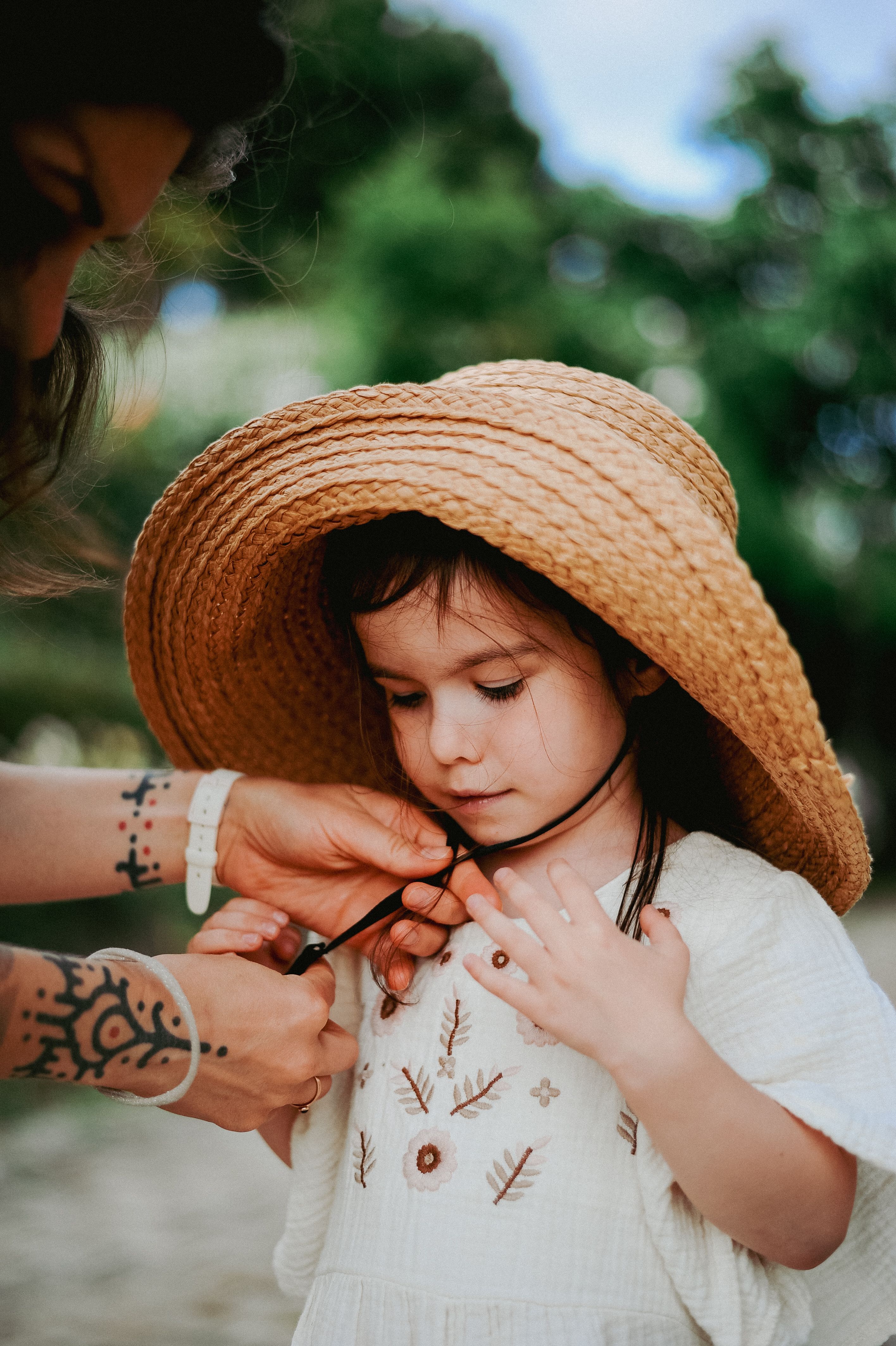 Woman Helping a Little Girl with Putting on a Hat · Free Stock Photo