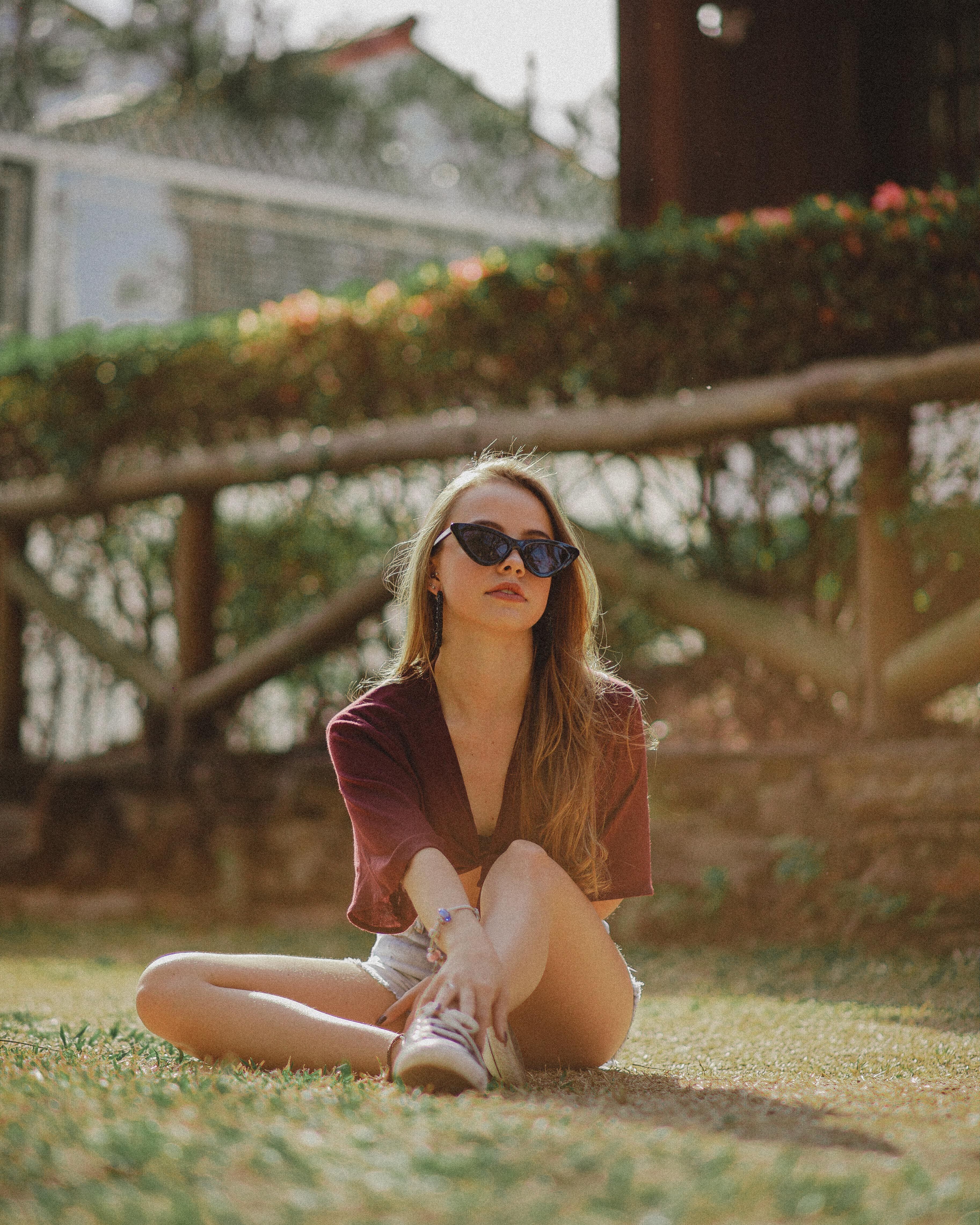 Woman in Short Sitting on Grass · Free Stock Photo