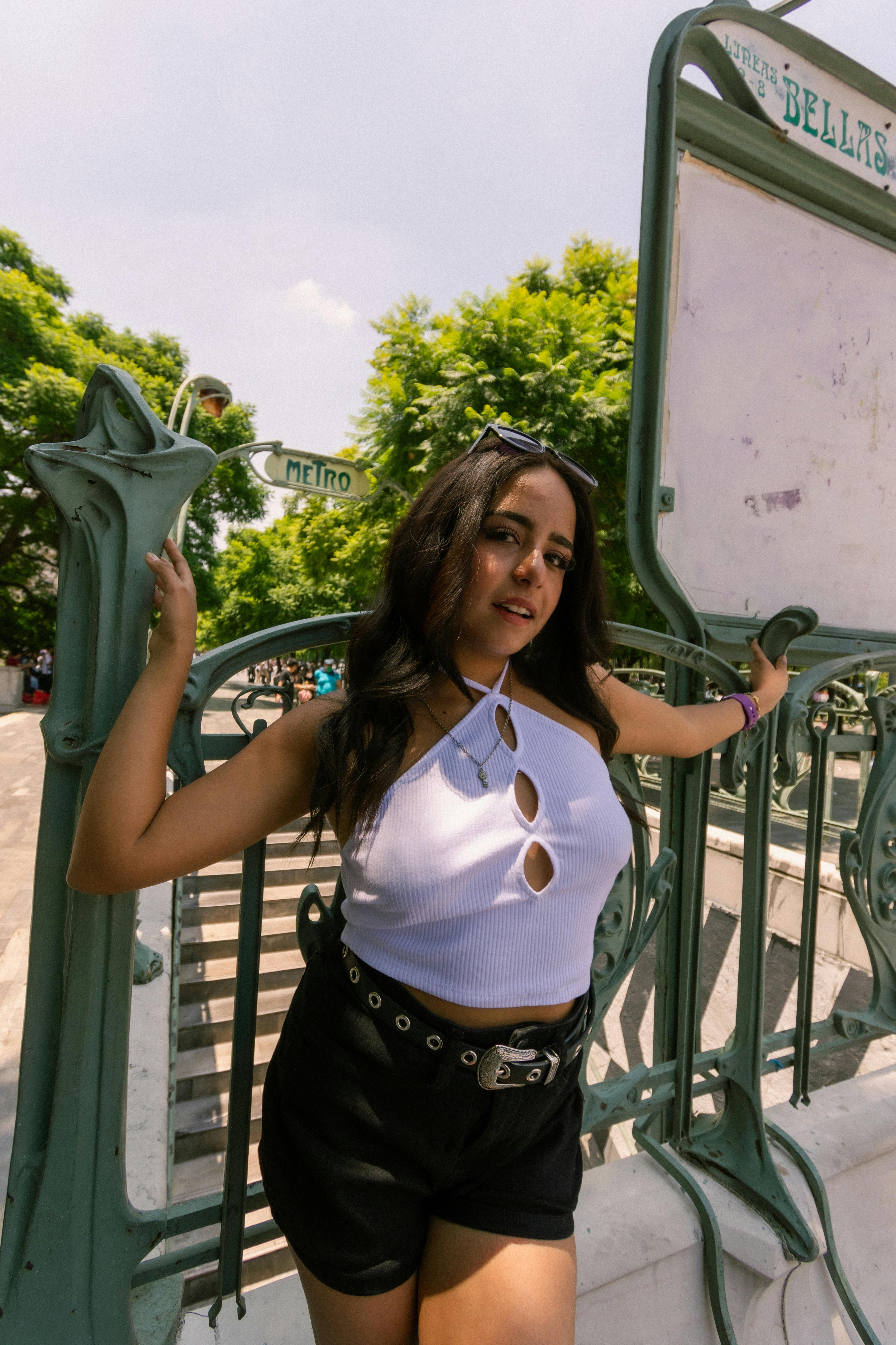 Female Model Wearing a White Halterneck Posing in front of a Railing ...