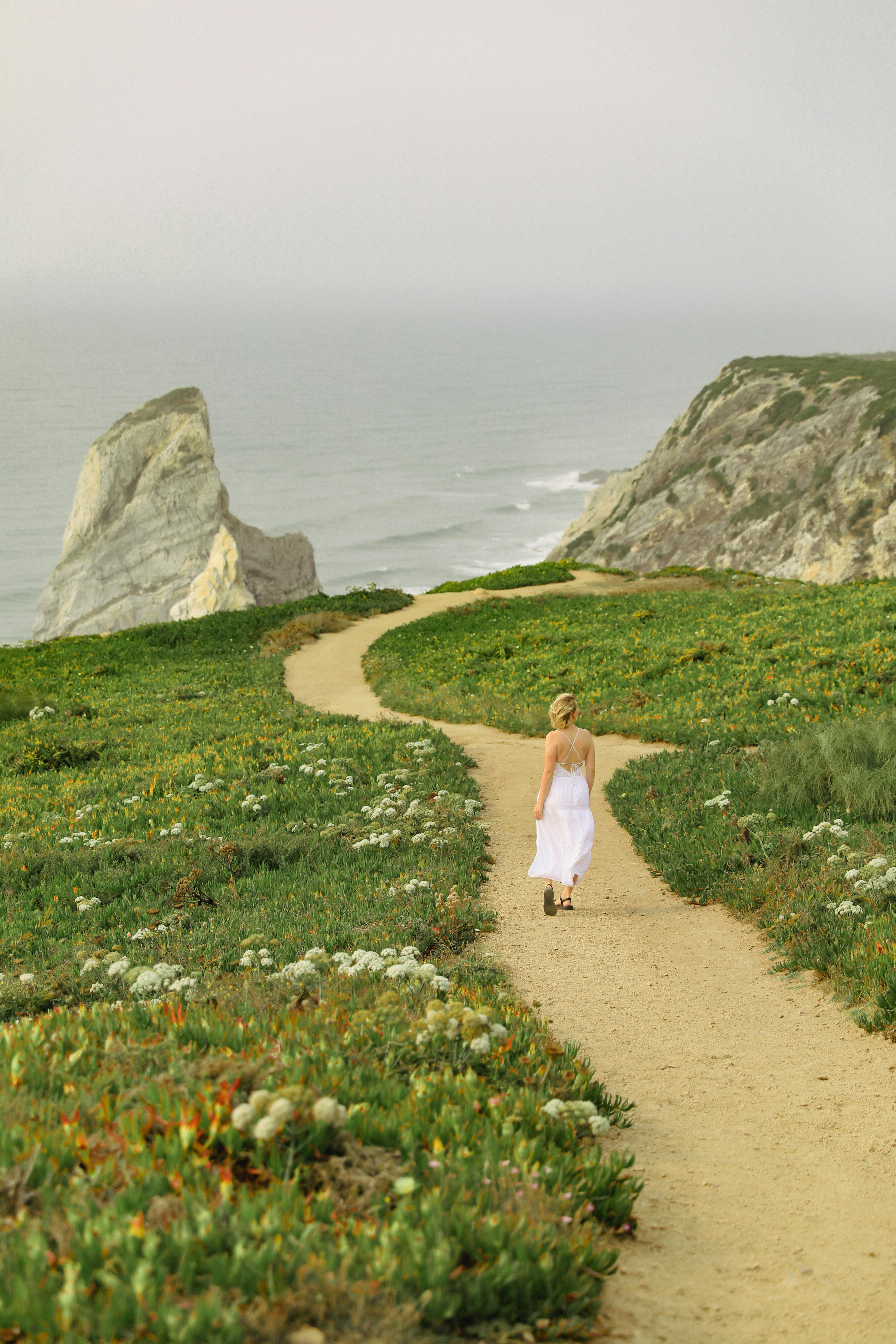 Woman Walking on Path on Rocky Seashore · Free Stock Photo
