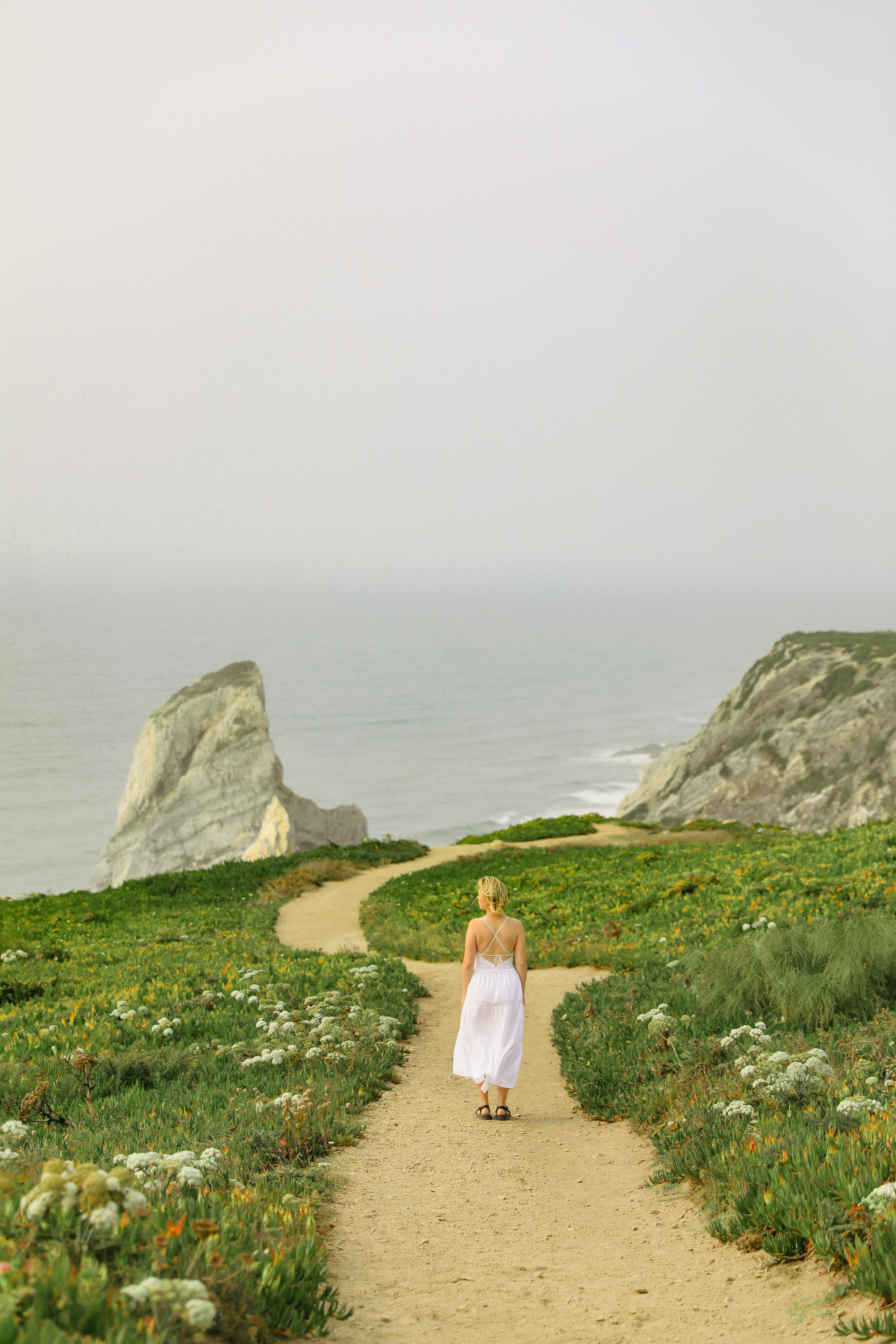 Woman in a White Dress Standing on a Trail near Ursa Beach, Cabo da ...
