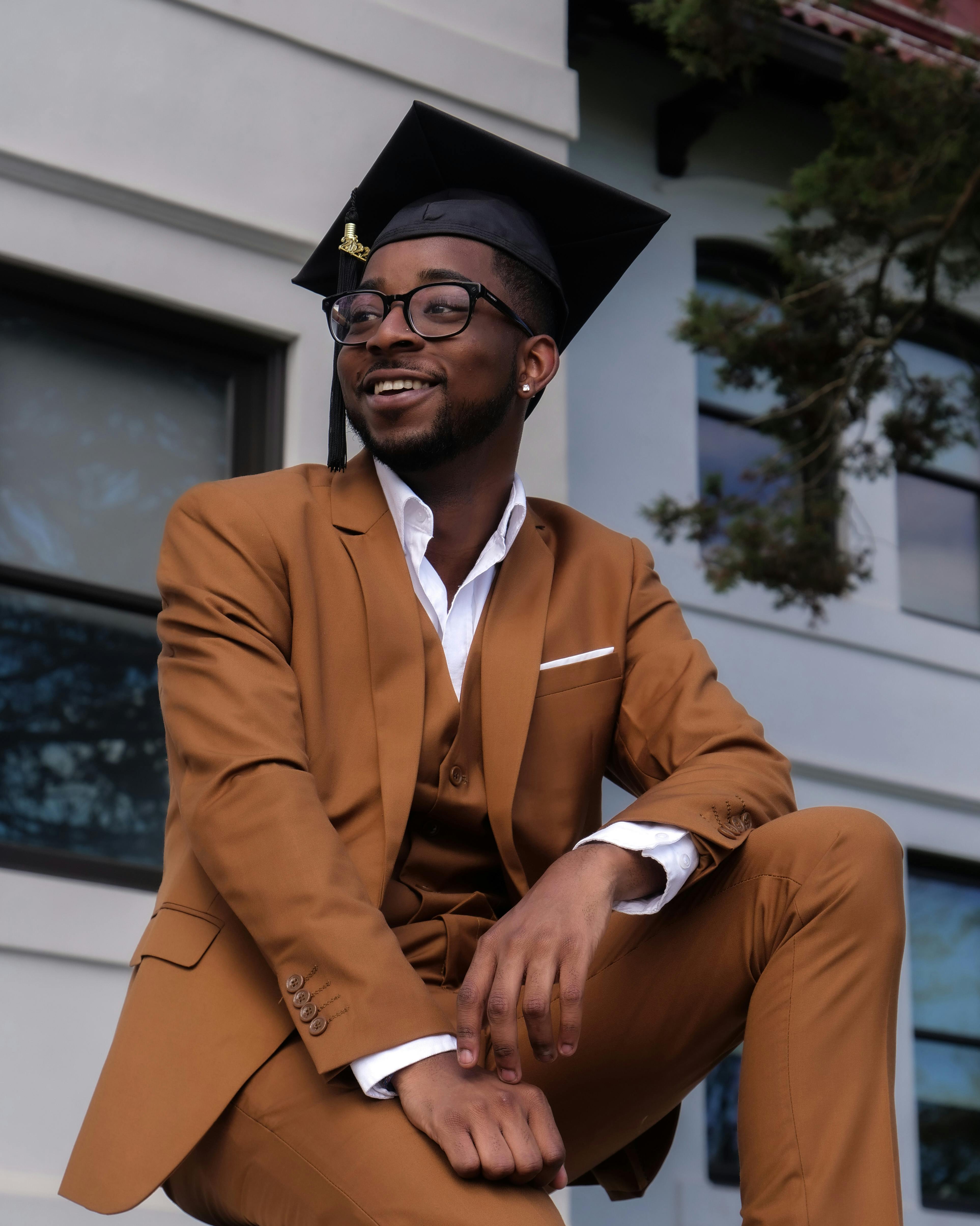 Smiling Graduate in Suit and Academic Hat · Free Stock Photo
