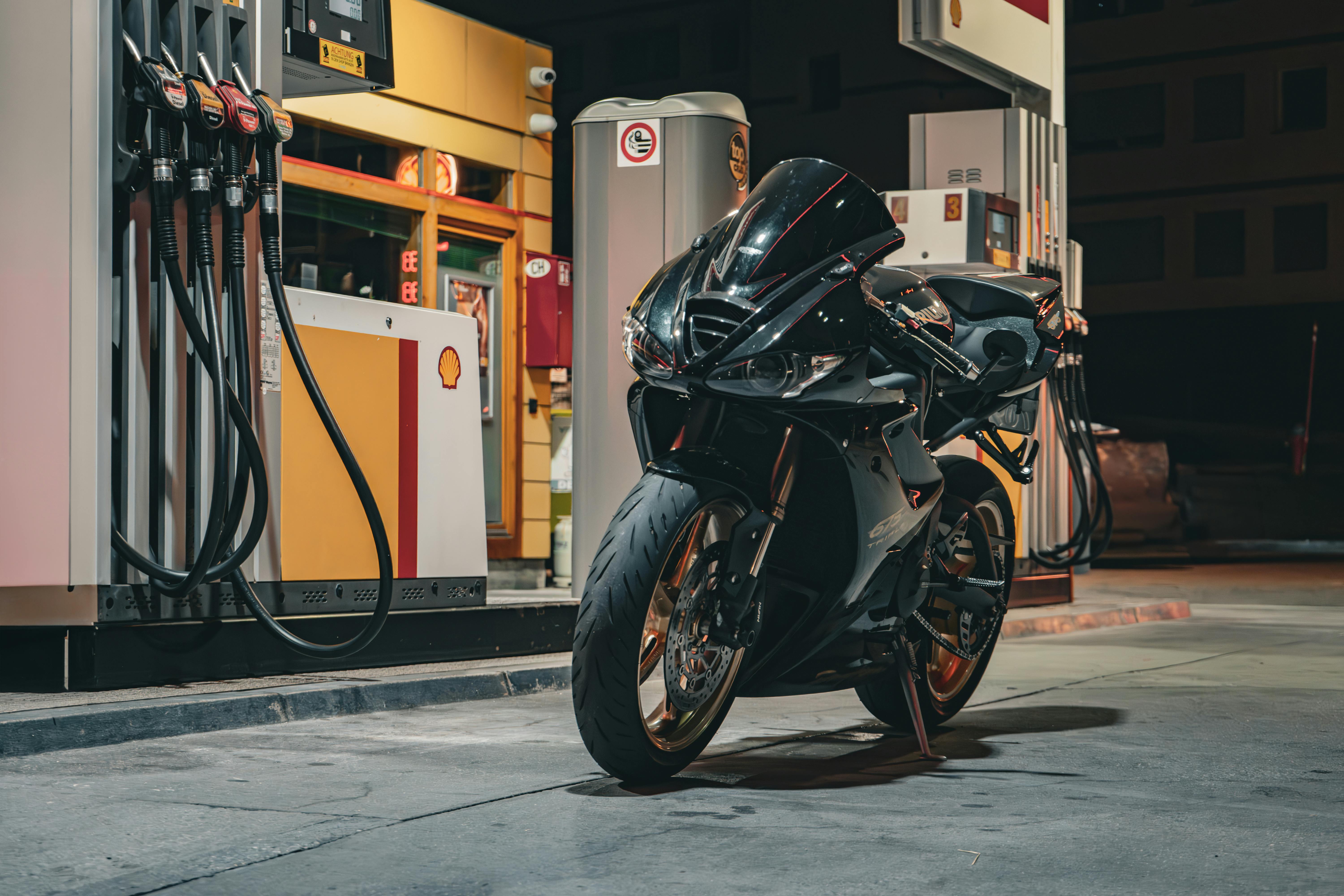 A motorcycle parked at a gas station at night · Free Stock Photo