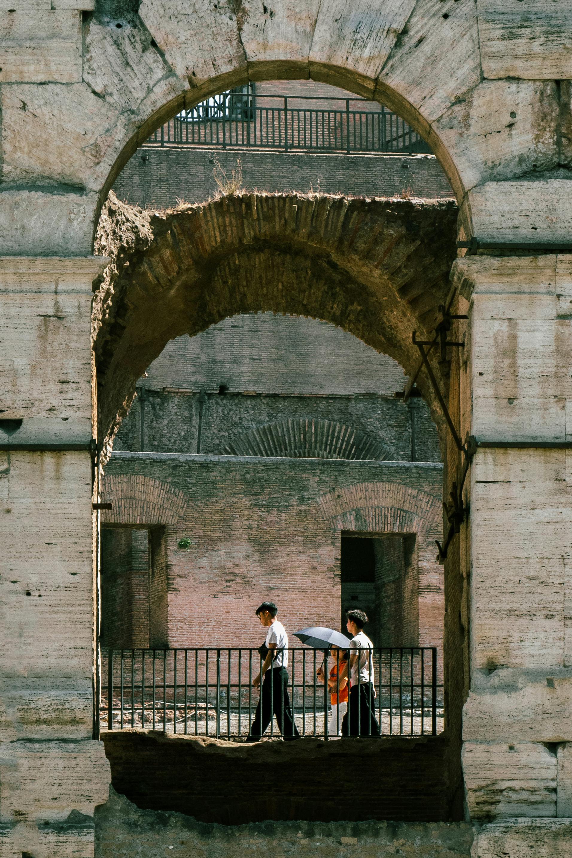 People Walking behind Arch in Town · Free Stock Photo