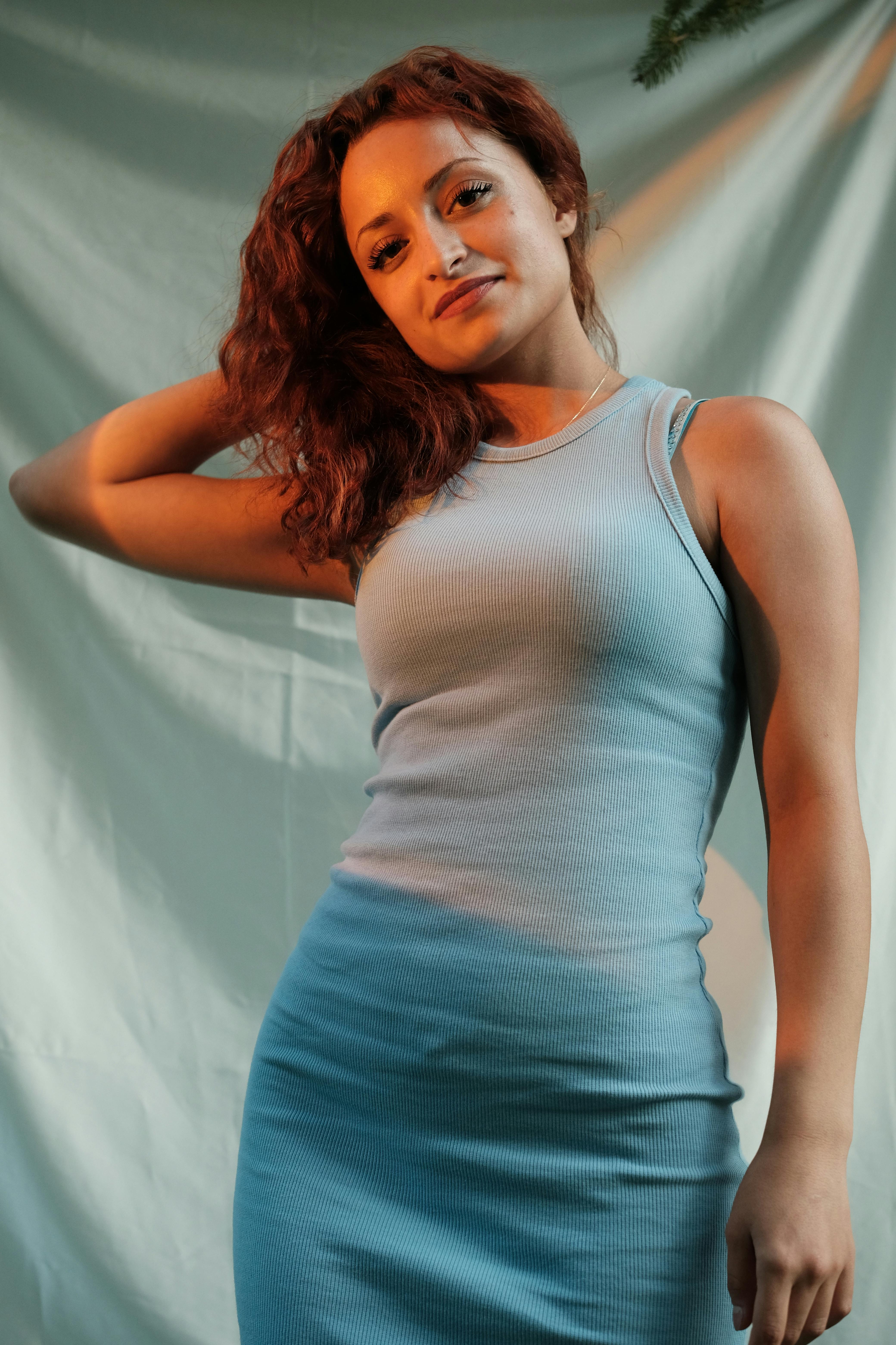 Young Woman Posing in a Blue Dress on the Background of a White Sheet ...