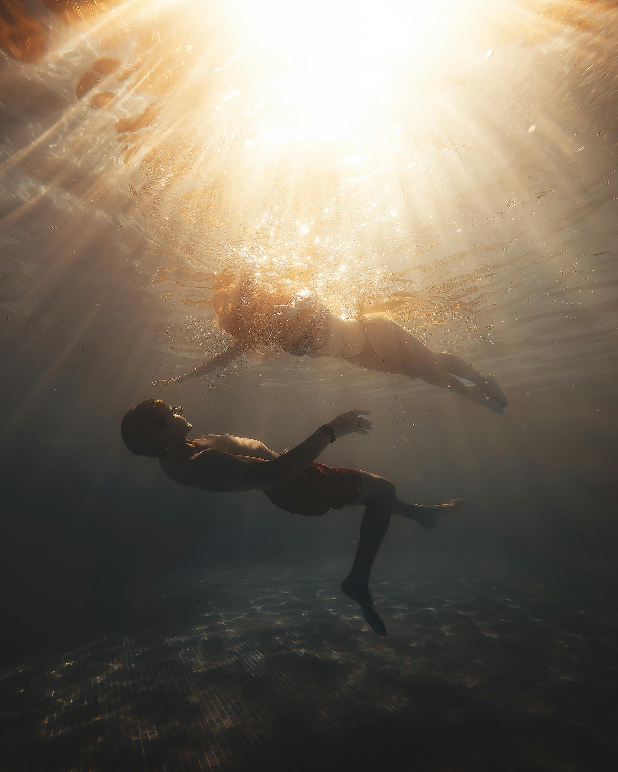 Sunlight over Couple Diving · Free Stock Photo