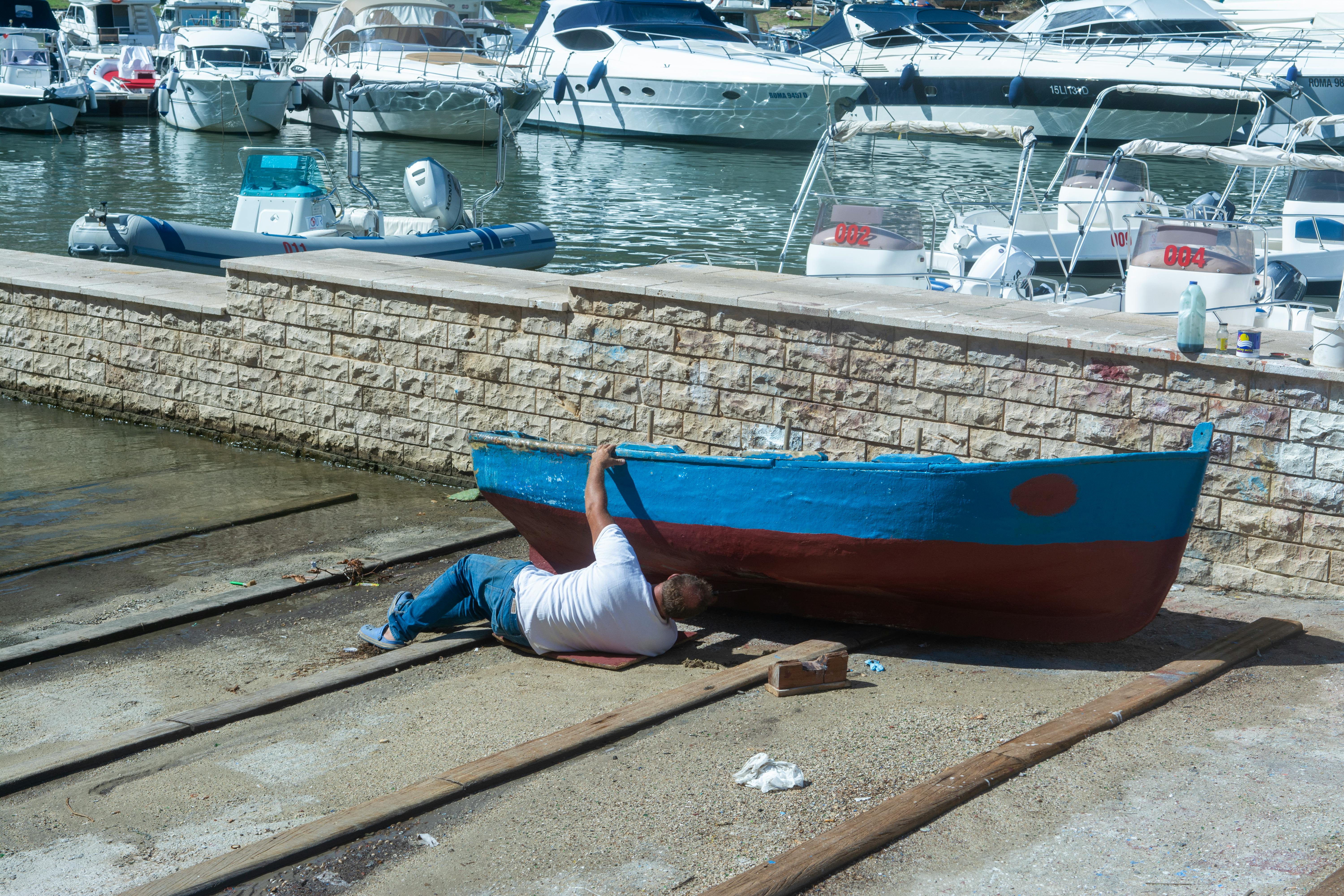 Man Fixing Boat in Port · Free Stock Photo