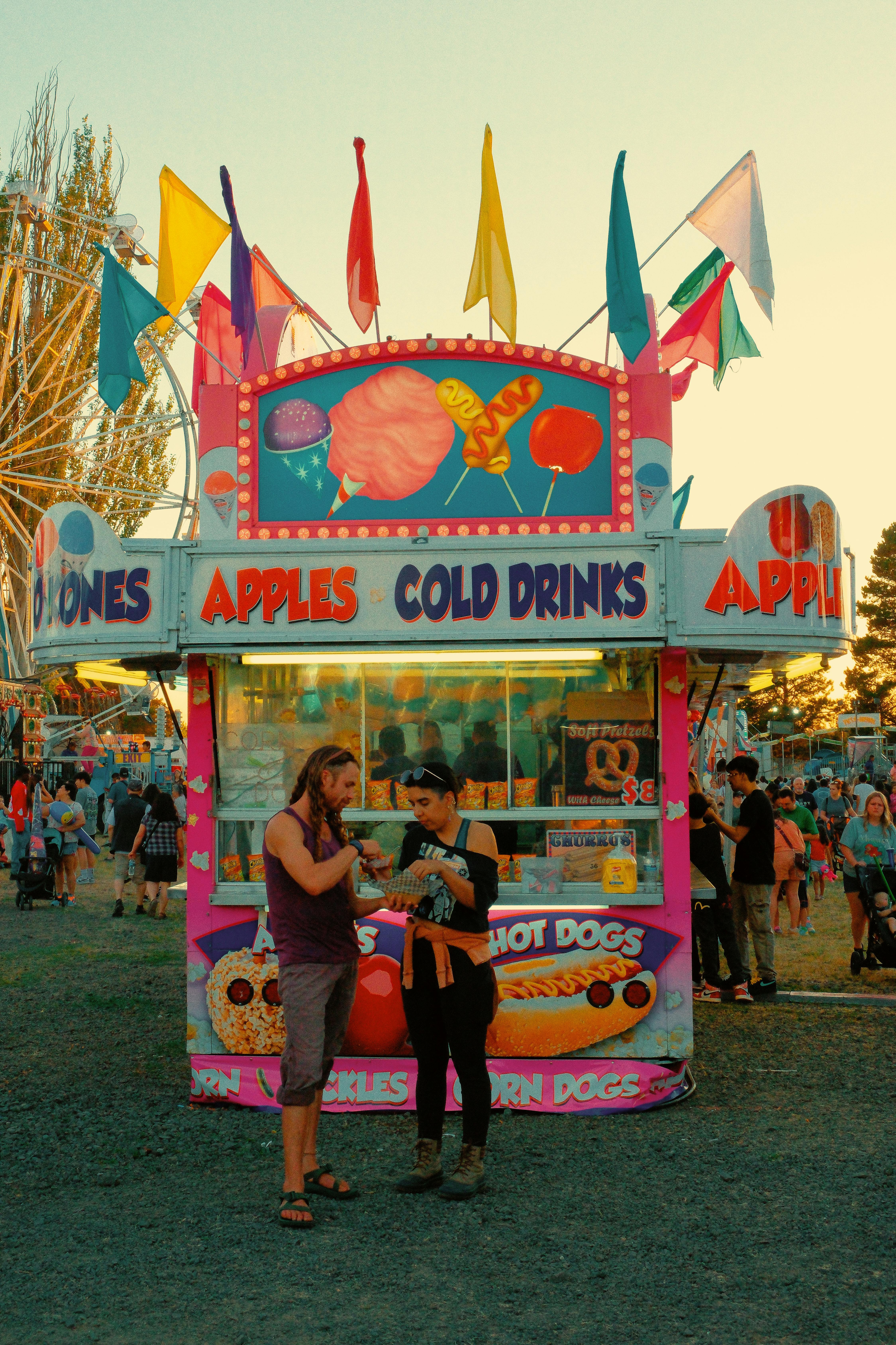 Couple in front of Booth with Food in Carnival · Free Stock Photo