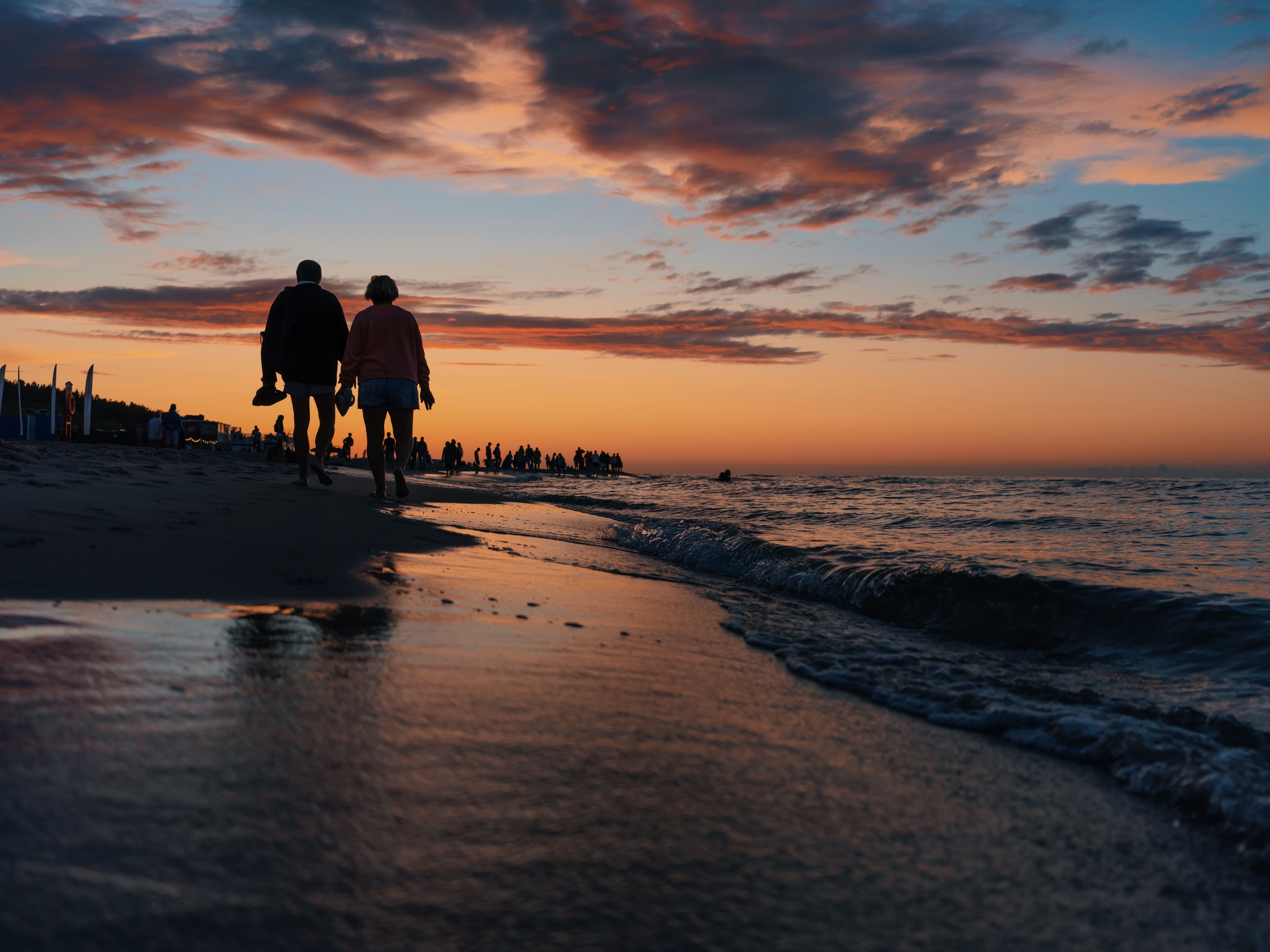 People Walking on a Beach During Sunset · Free Stock Photo