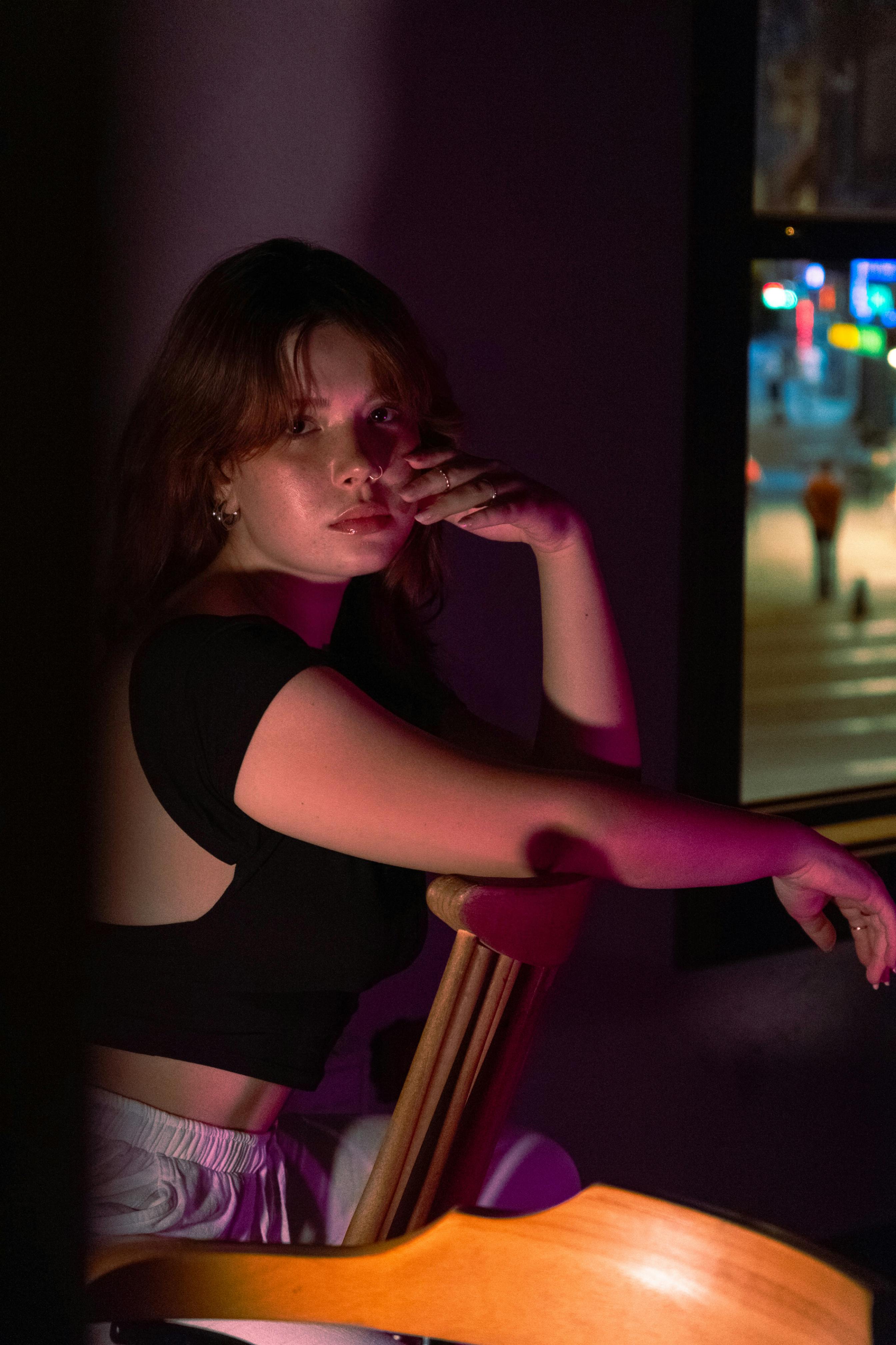 Young Woman Sitting on a Chair in Dim Light · Free Stock Photo