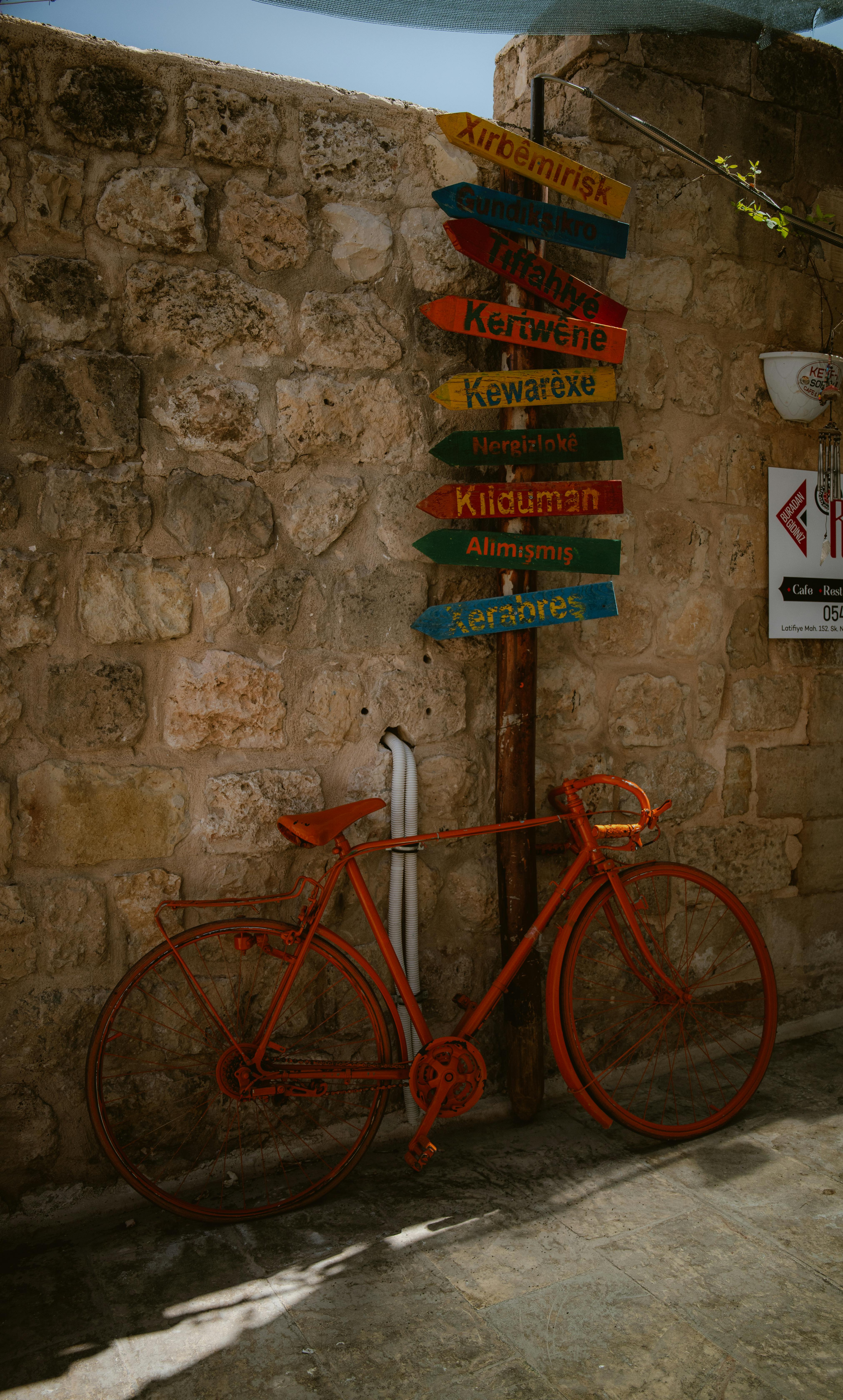 Red Bike Leaning against Direction Sing · Free Stock Photo