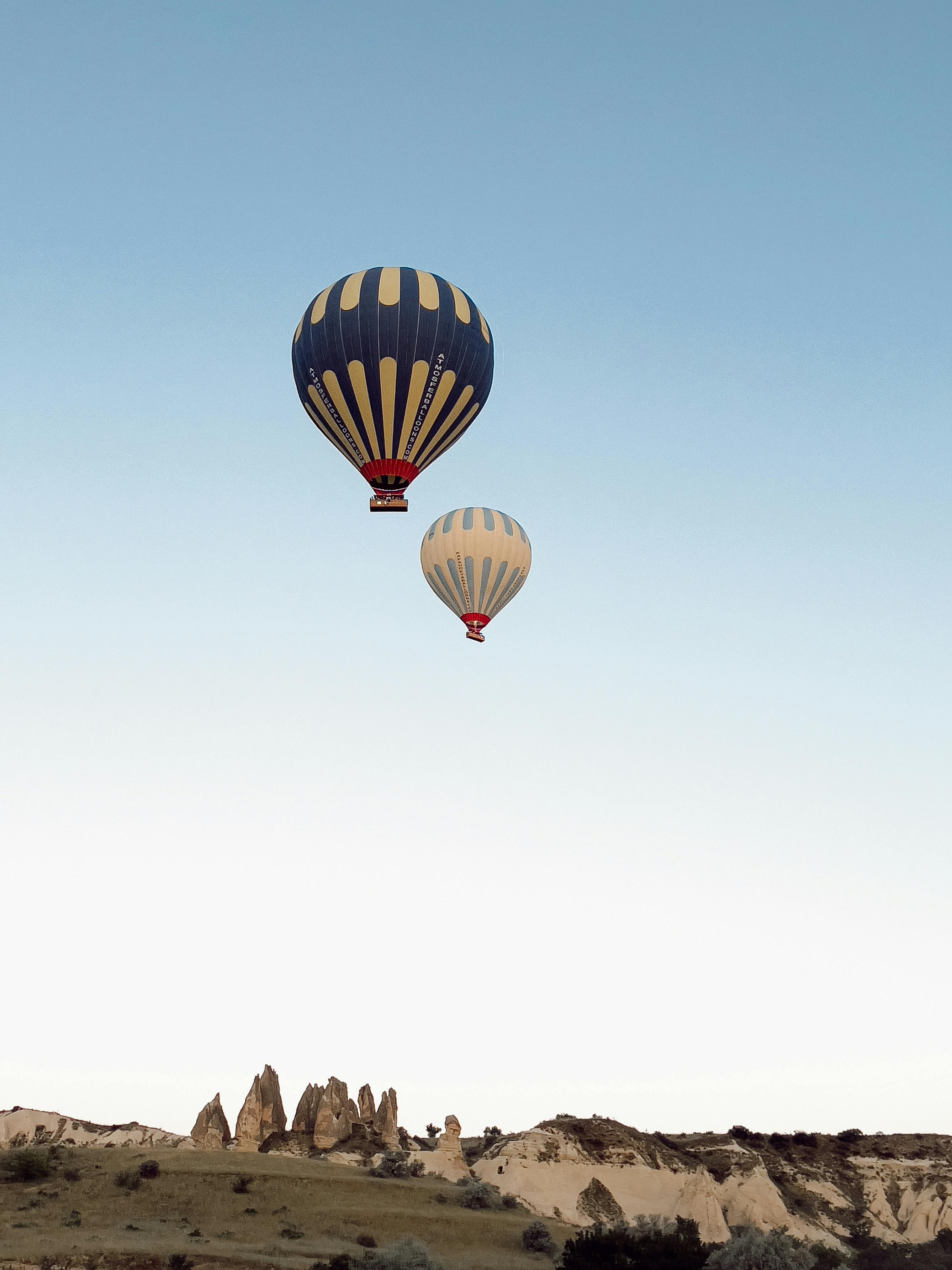 Two Colorful Balloons Flying over Rock Formations in Cappadocia, Turkey ...