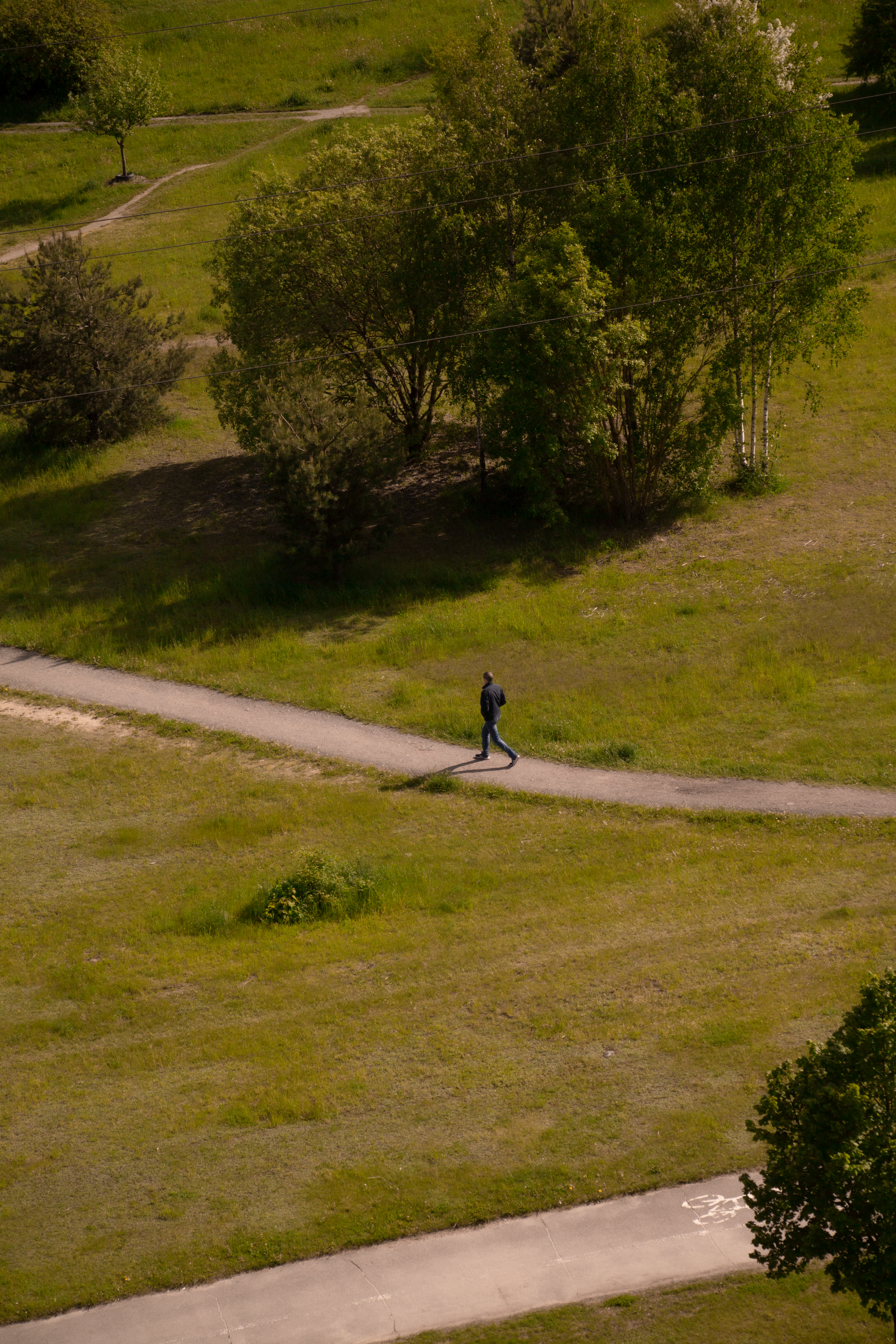 Man Walking on Sunlit Footpath · Free Stock Photo