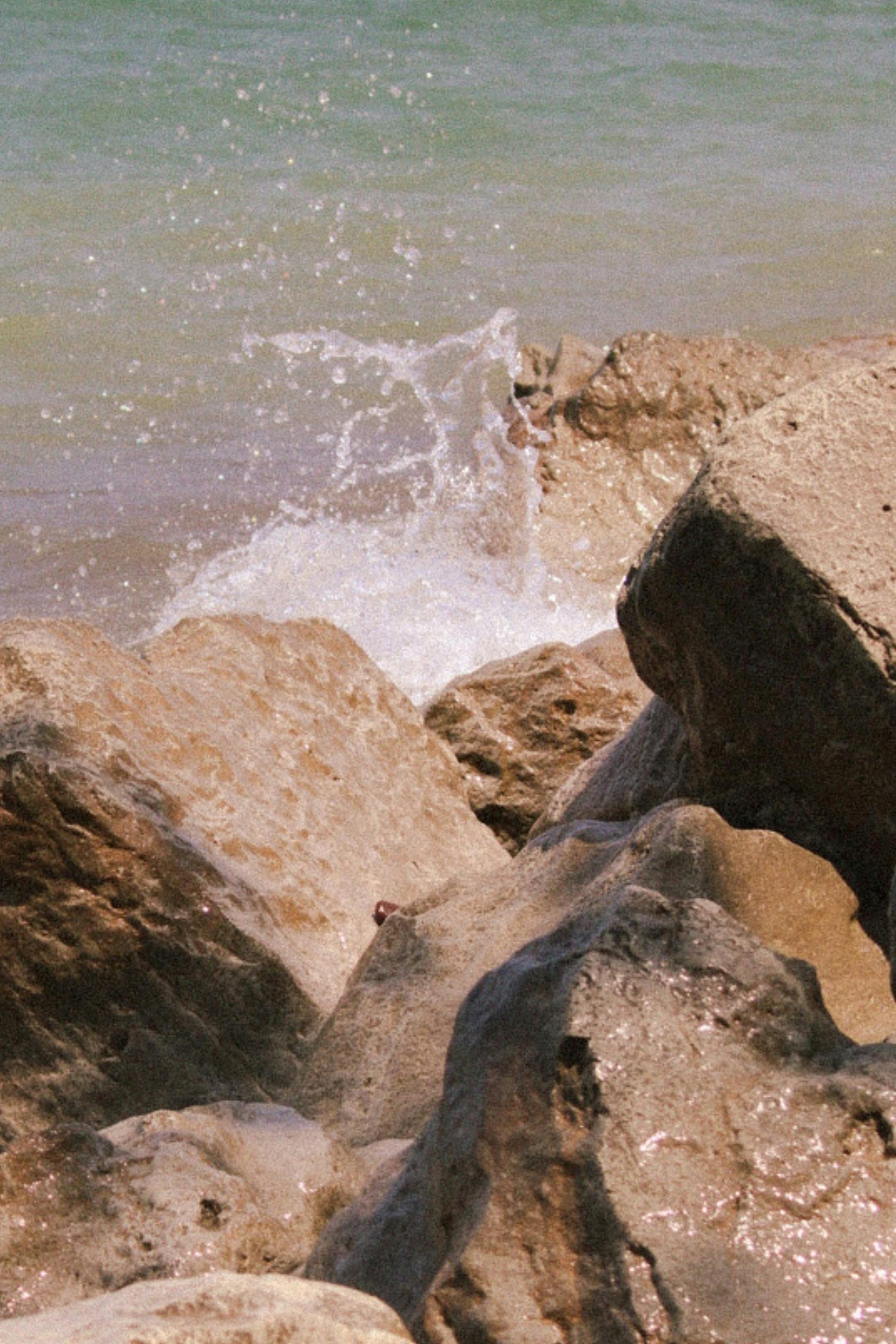 Wave Crushing on Sunlit Rocks · Free Stock Photo