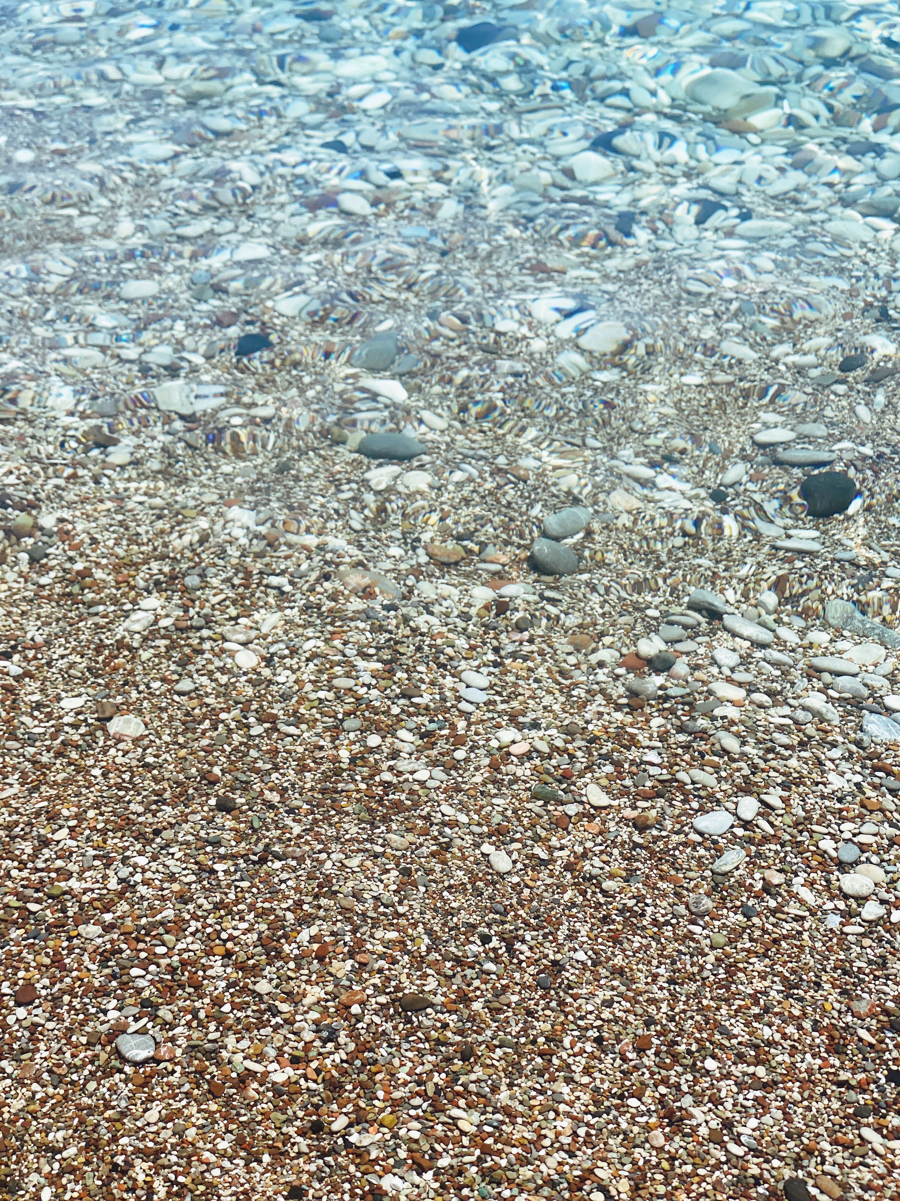 A beach with pebbles and sand on the surface · Free Stock Photo