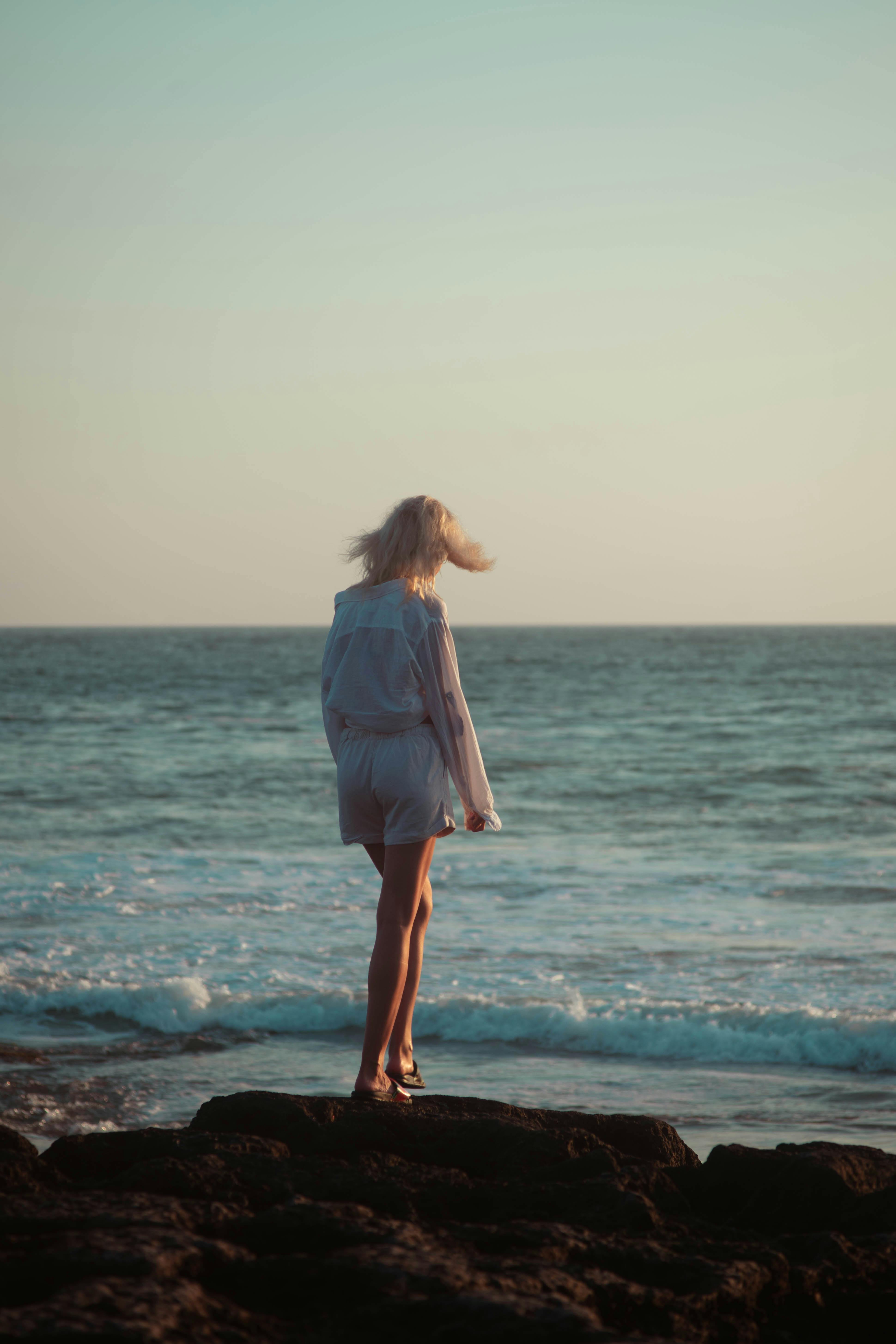 Woman Standing on Sea Shore · Free Stock Photo